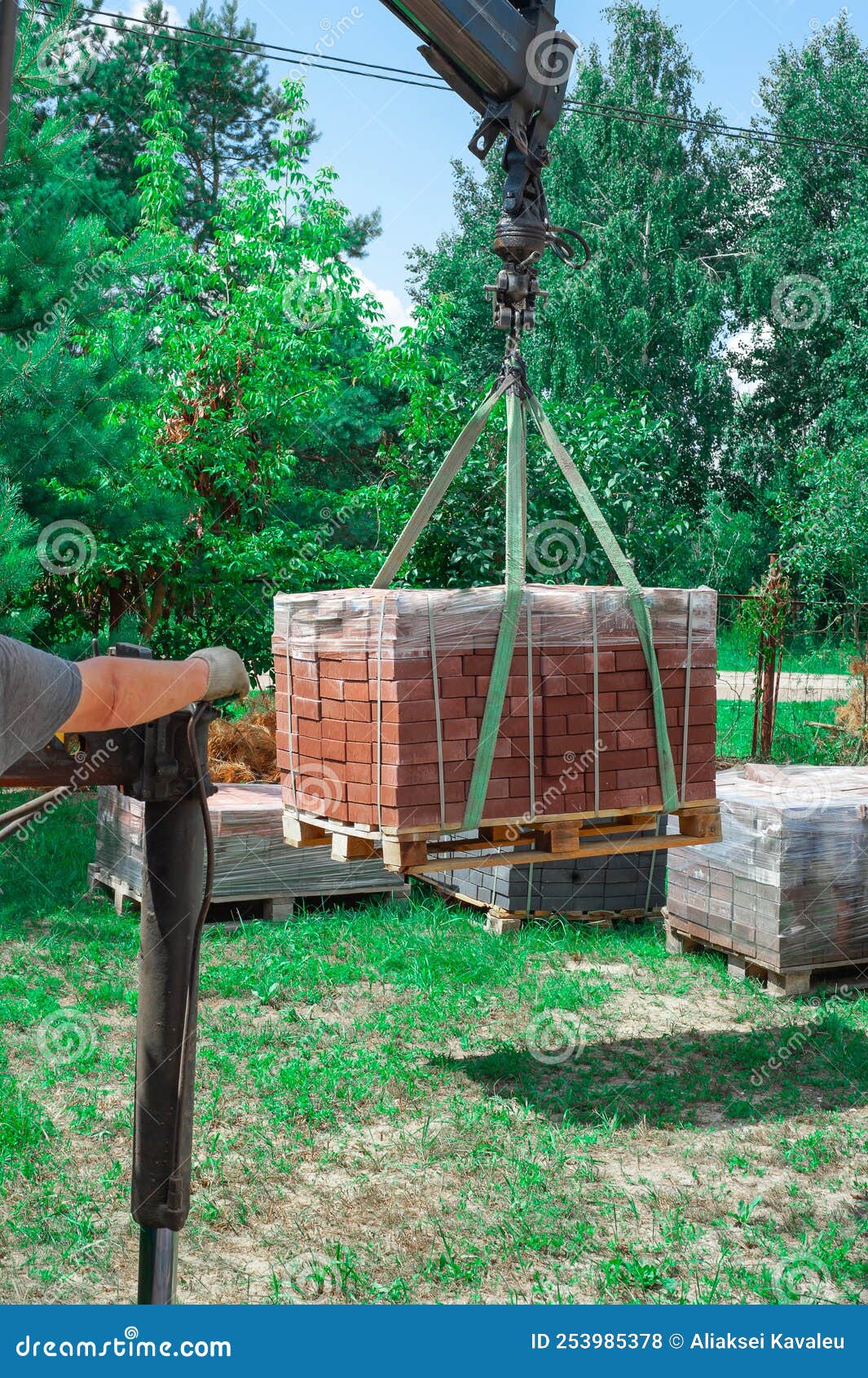Unloading Paving Slabs from a Truck. Men Unload Paving Slabs Using a ...