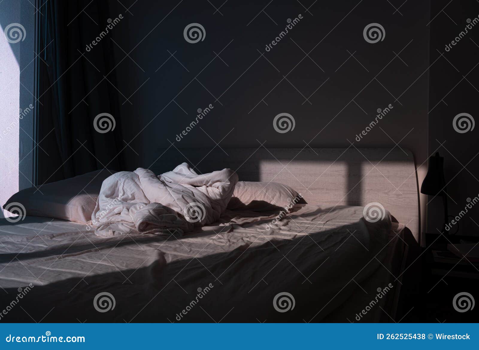 Unmade Empty Bed in the Dramatic Dim Light Coming from a Window Stock ...