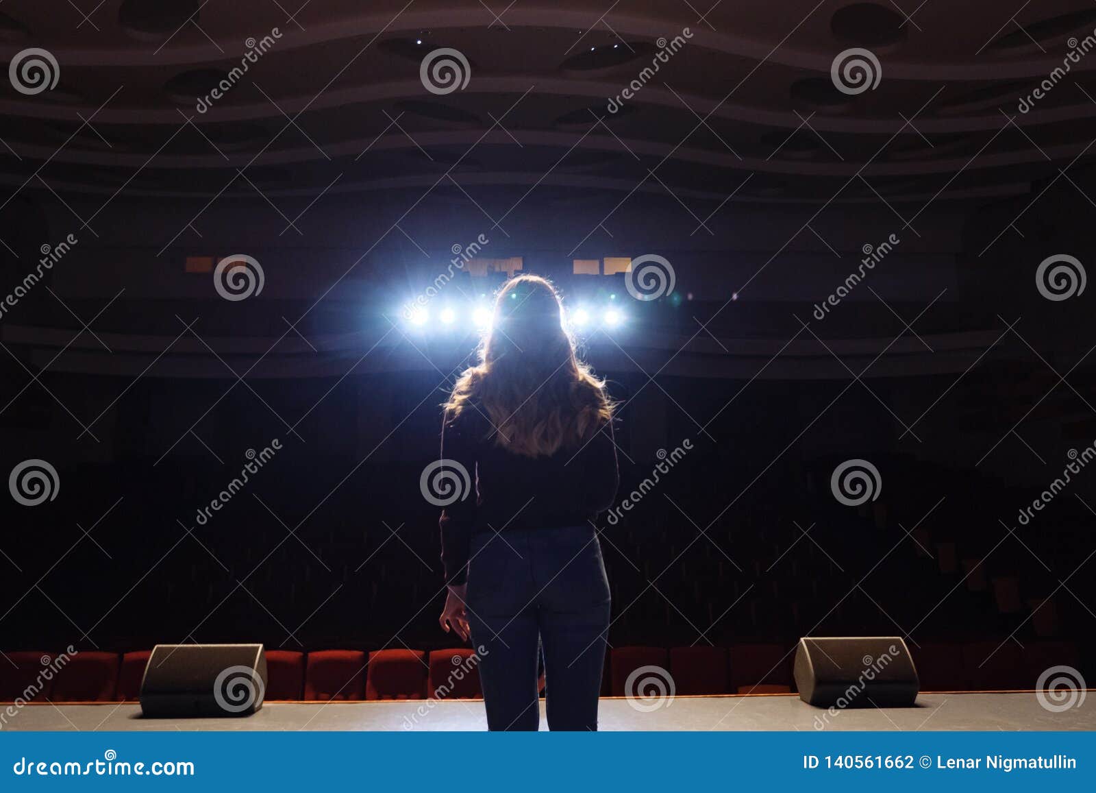 The Unrecognizable Girl Singing on the Stage in Front of the Spotlight ...