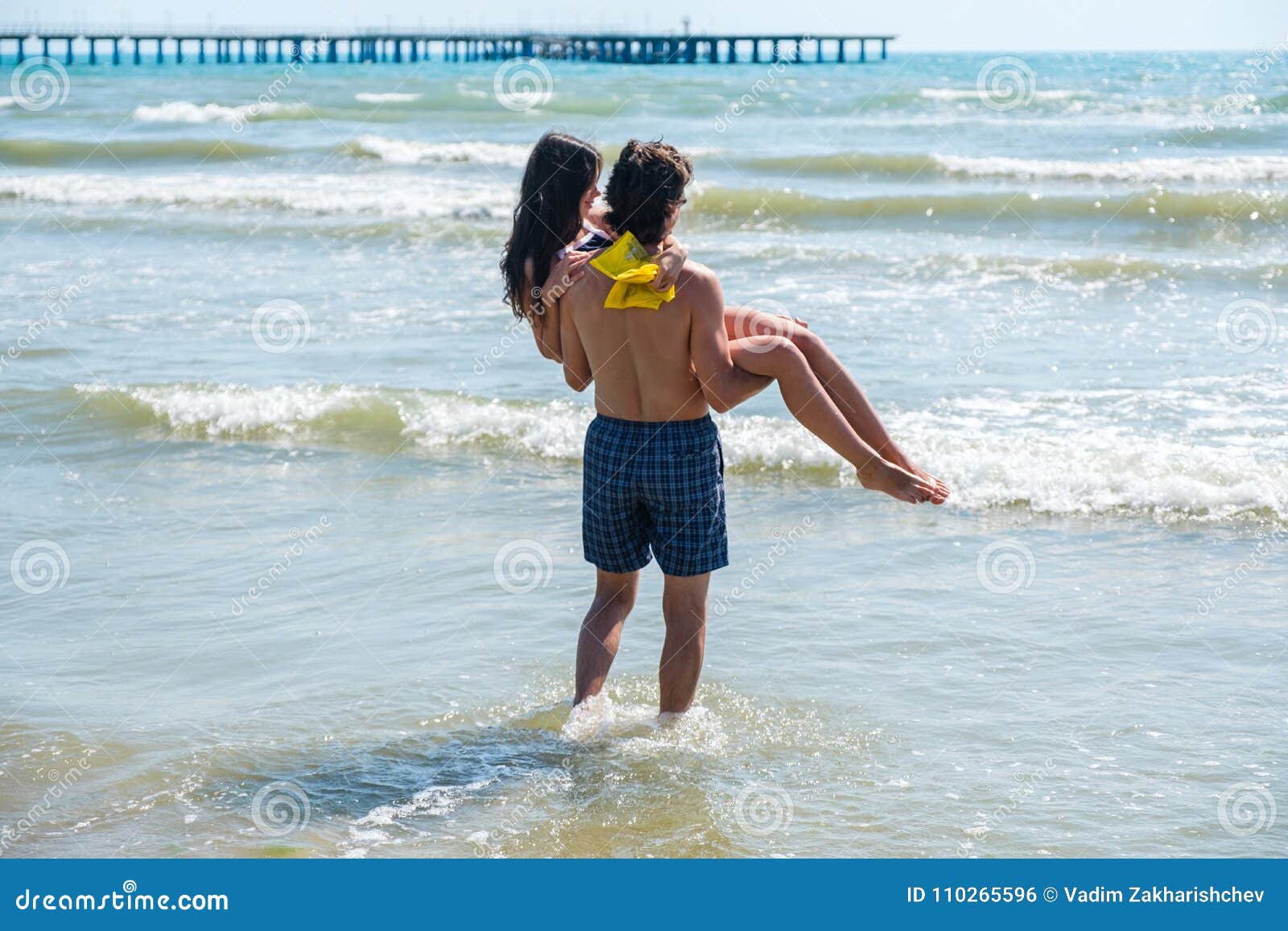 Unrecognizable Pair Of Brunettes Man Carries A Woman In His Arms At