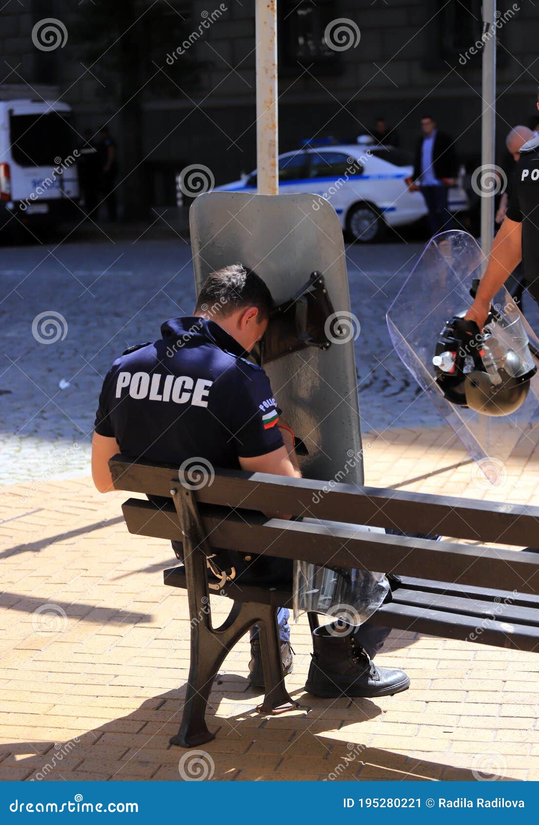 Unrecognizable Police Officer Sleeps on a Bench Over His Shield ...