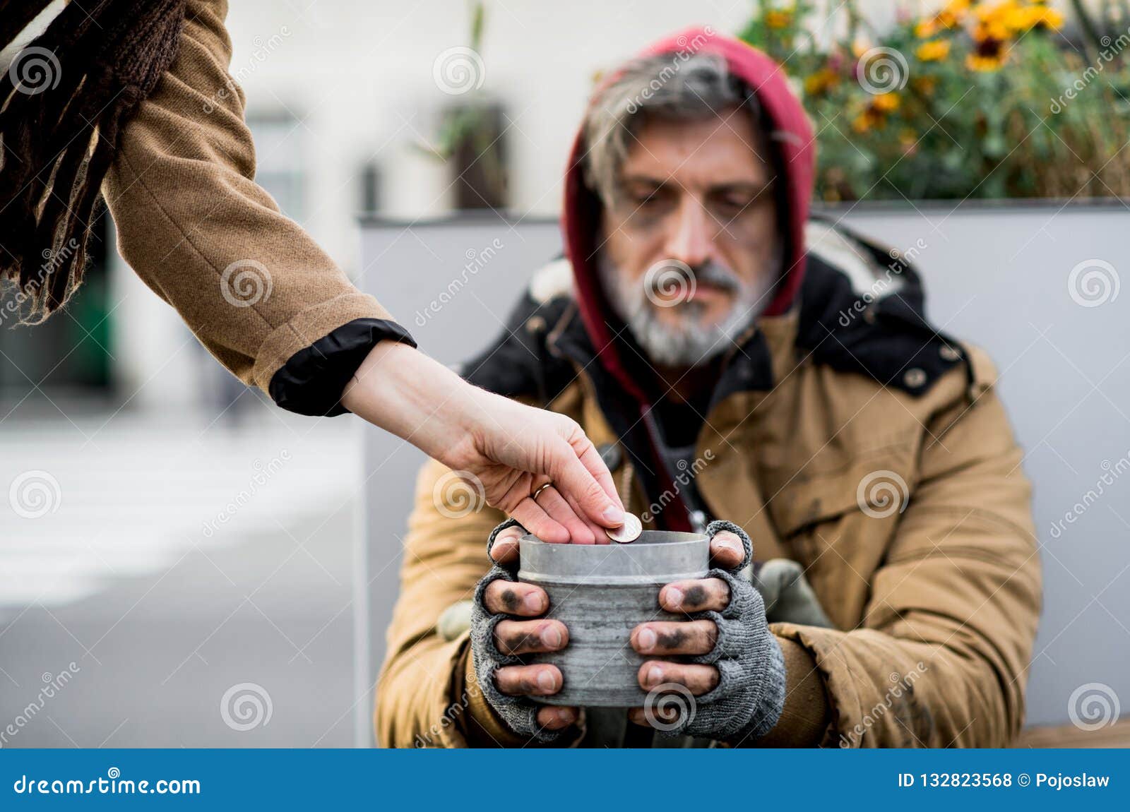 Unrecognizable Woman Giving Money To Homeless Beggar Man Sitting In