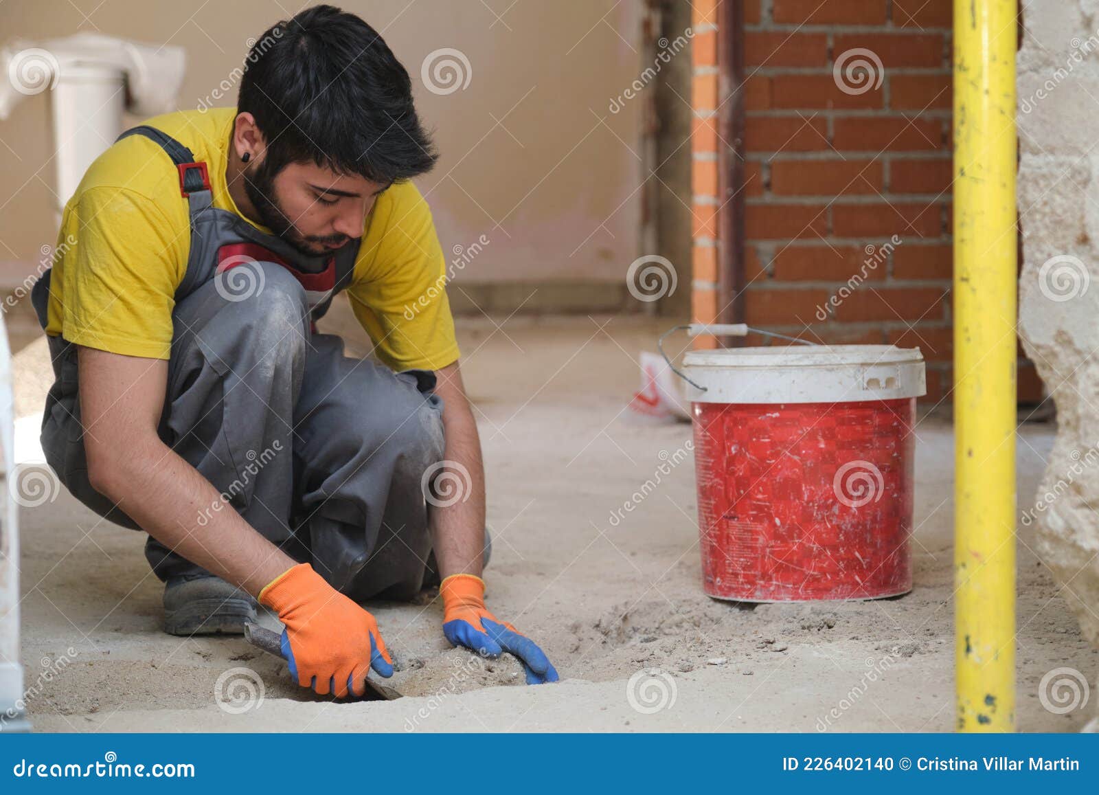 Unrecognizable Young Builder Shoveling Sand at a Construction Site ...