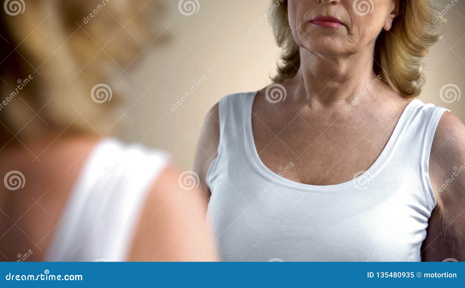 Unsatisfied Senior Woman Looking In Mirror At Her Wrinkled Body Aging