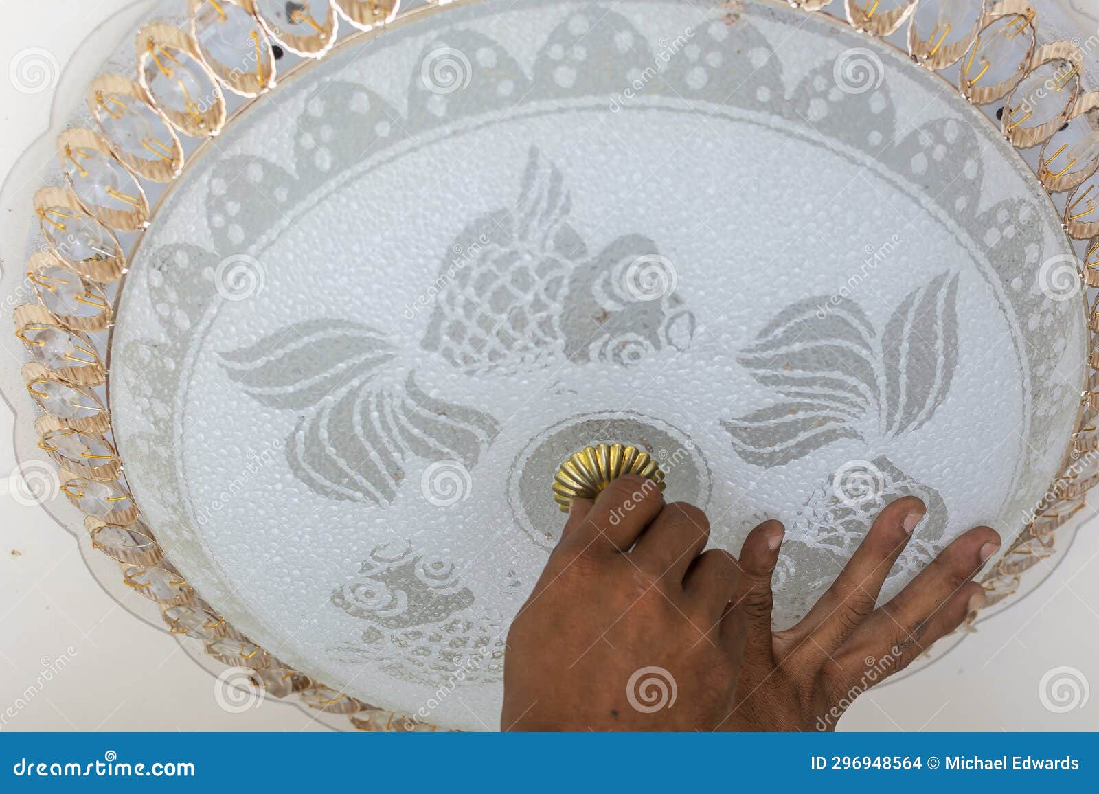 Unscrewing the Knob Securing the Lamp Cover of a Dome LED Light Mounted ...