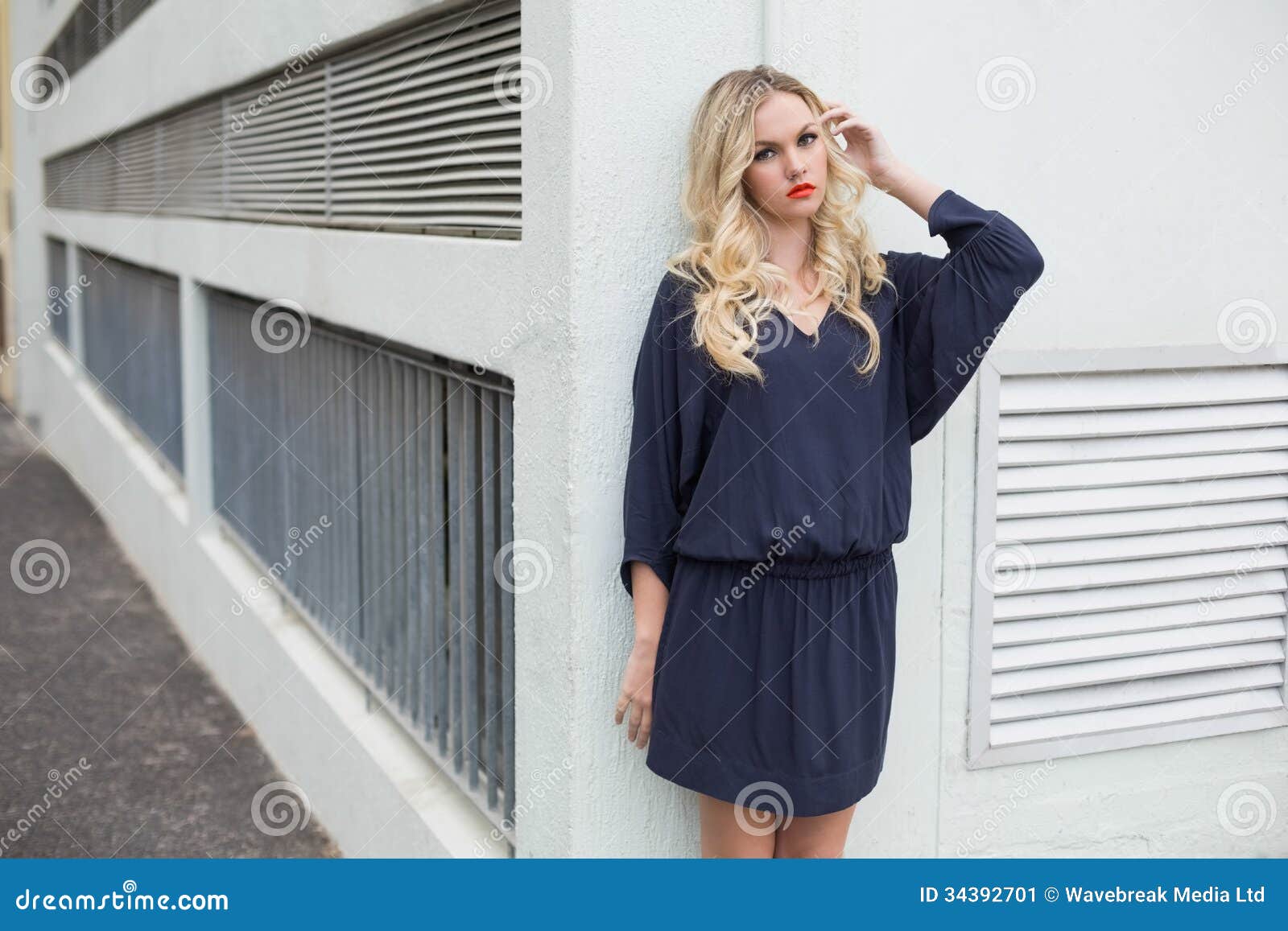 Unsmiling Blonde Wearing Classy Dress Posing Outdoors Stock Image