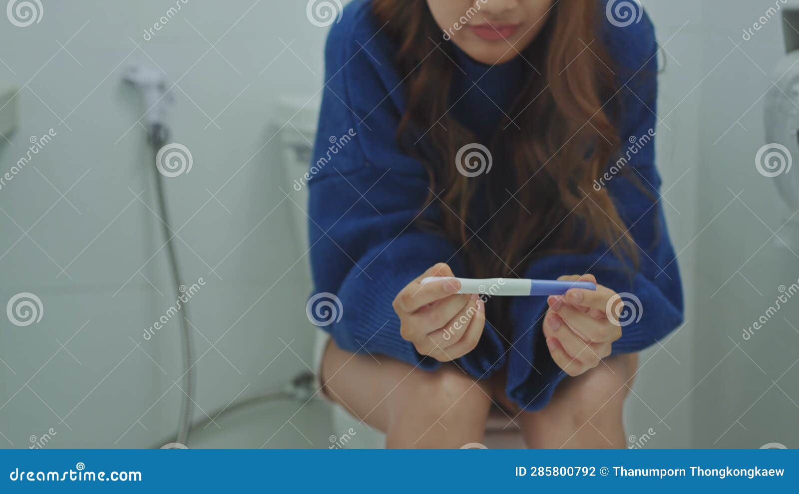 Unstressed Woman Sitting On Toilet And Waiting For Pregnancy Test