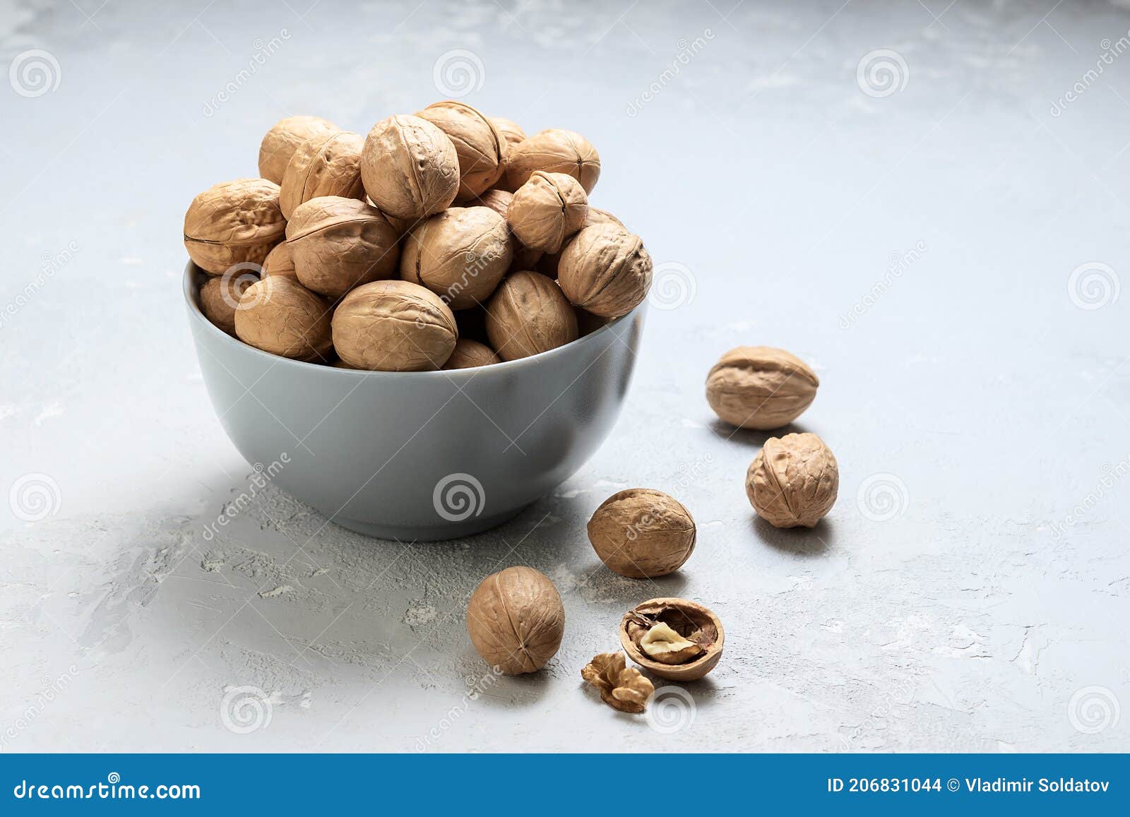 Untreated Walnut in a Bowl on a Grey Concrete Background with a Copy ...