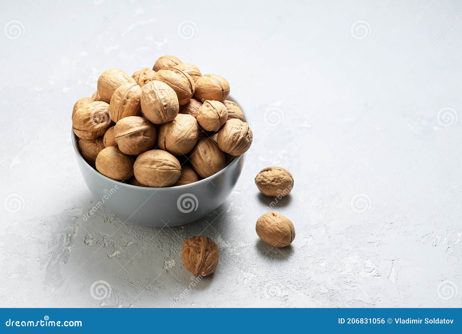 Untreated Walnut in a Bowl on a Grey Concrete Background with a Copy ...