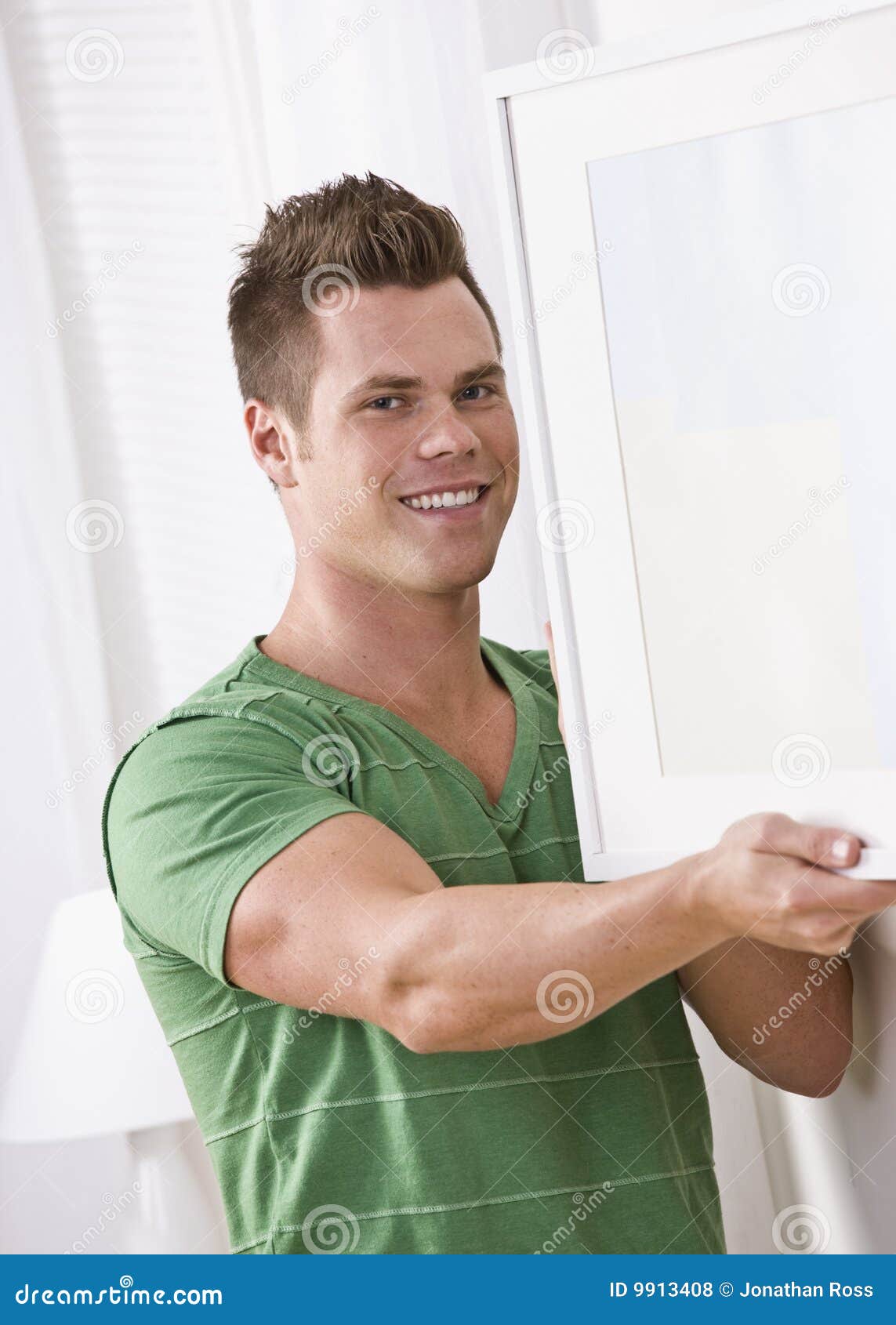 Uomo Che Appende Una Cornice Fotografia Stock - Immagine di felicità ...