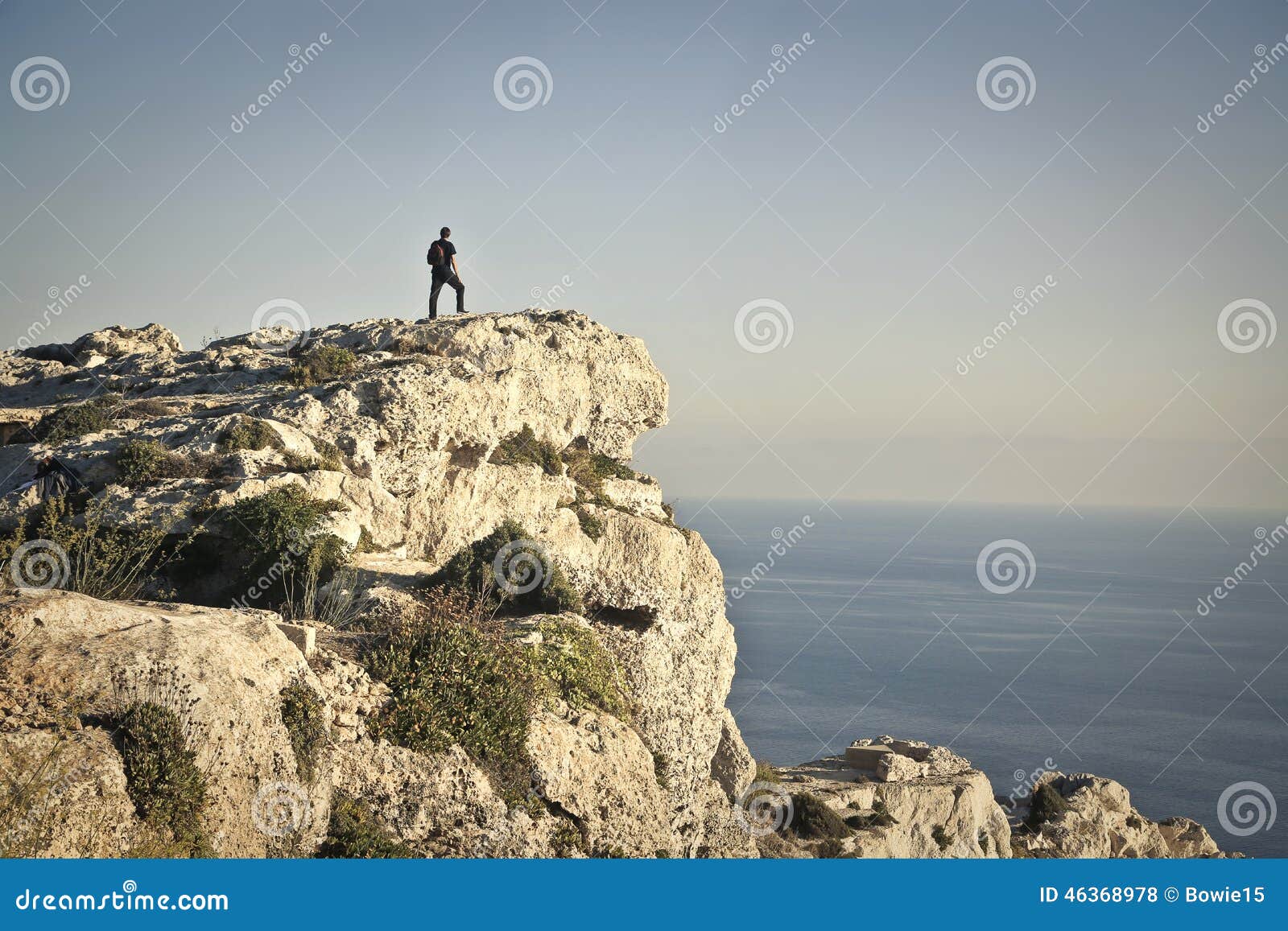 Uomo Che Guarda L'orizzonte Da Una Roccia Fotografia Stock - Immagine ...
