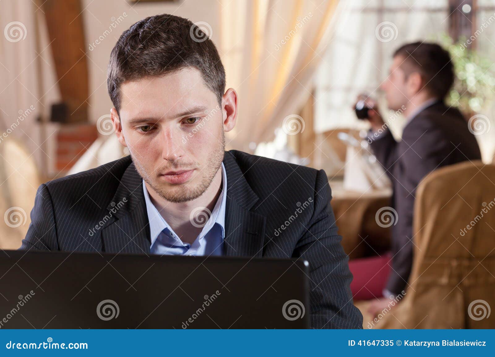 Uomo Che Lavora Al Computer Portatile in Ristorante Immagine Stock ...