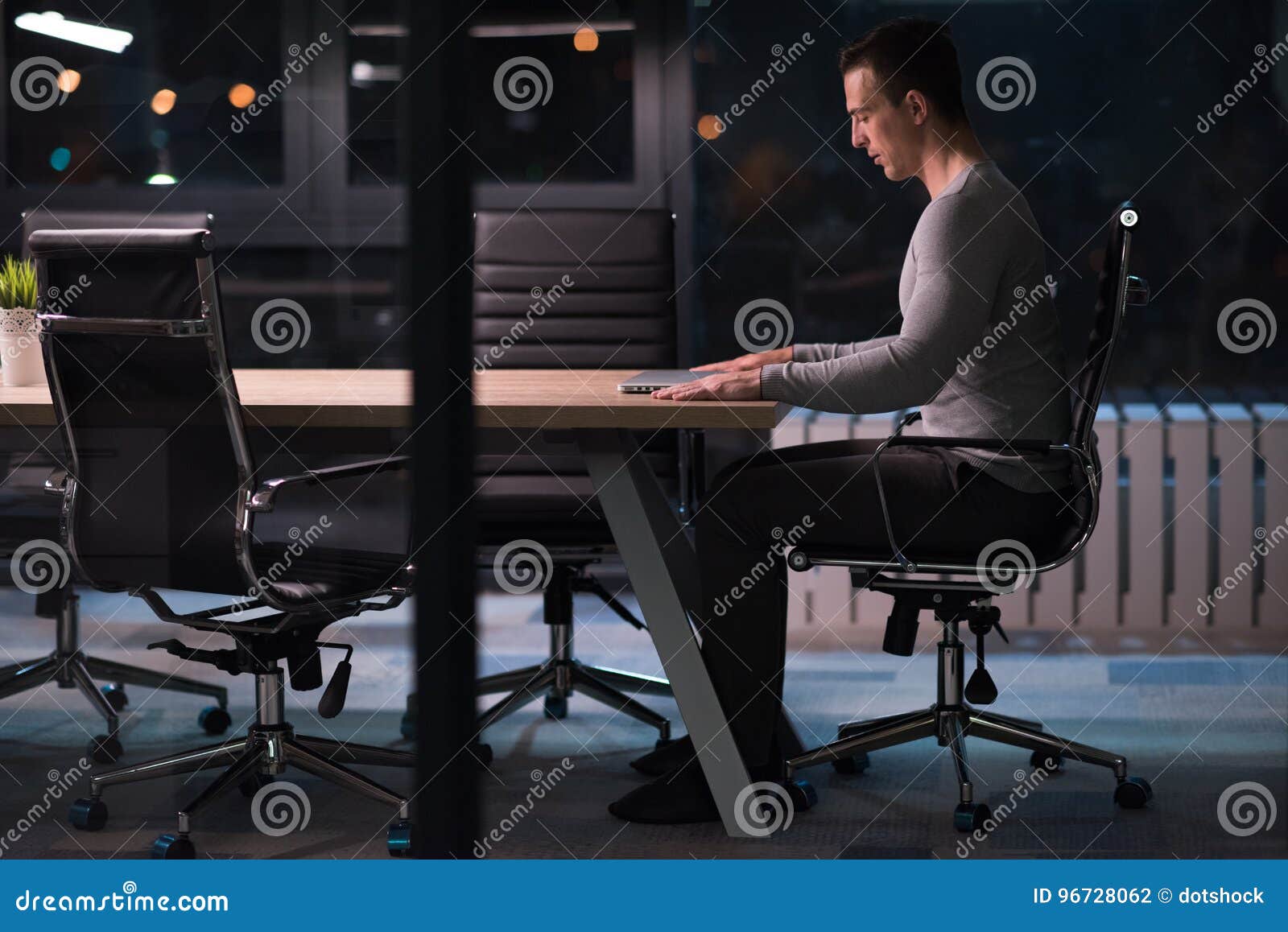 Uomo Che Lavora Al Computer Portatile in Ufficio Scuro Fotografia Stock ...