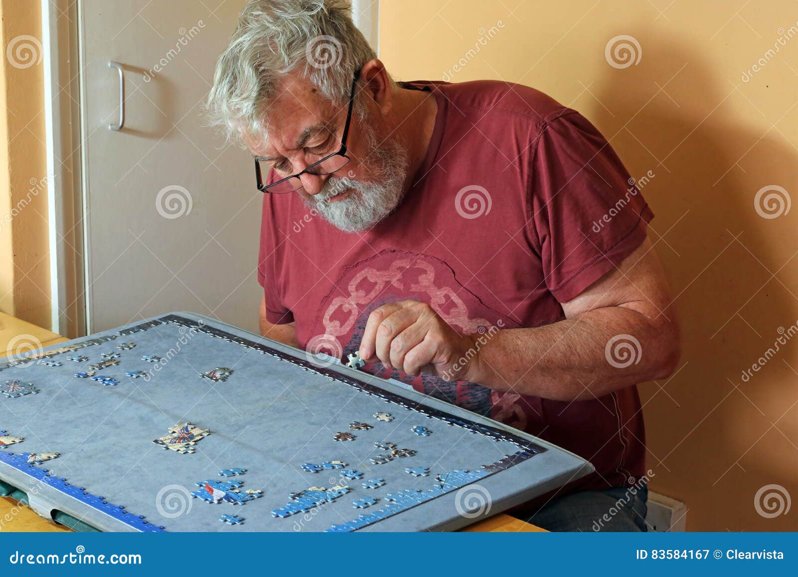 Uomo Senior Sul Suo Proprio Fare Un Puzzle Immagine Stock - Immagine di ...