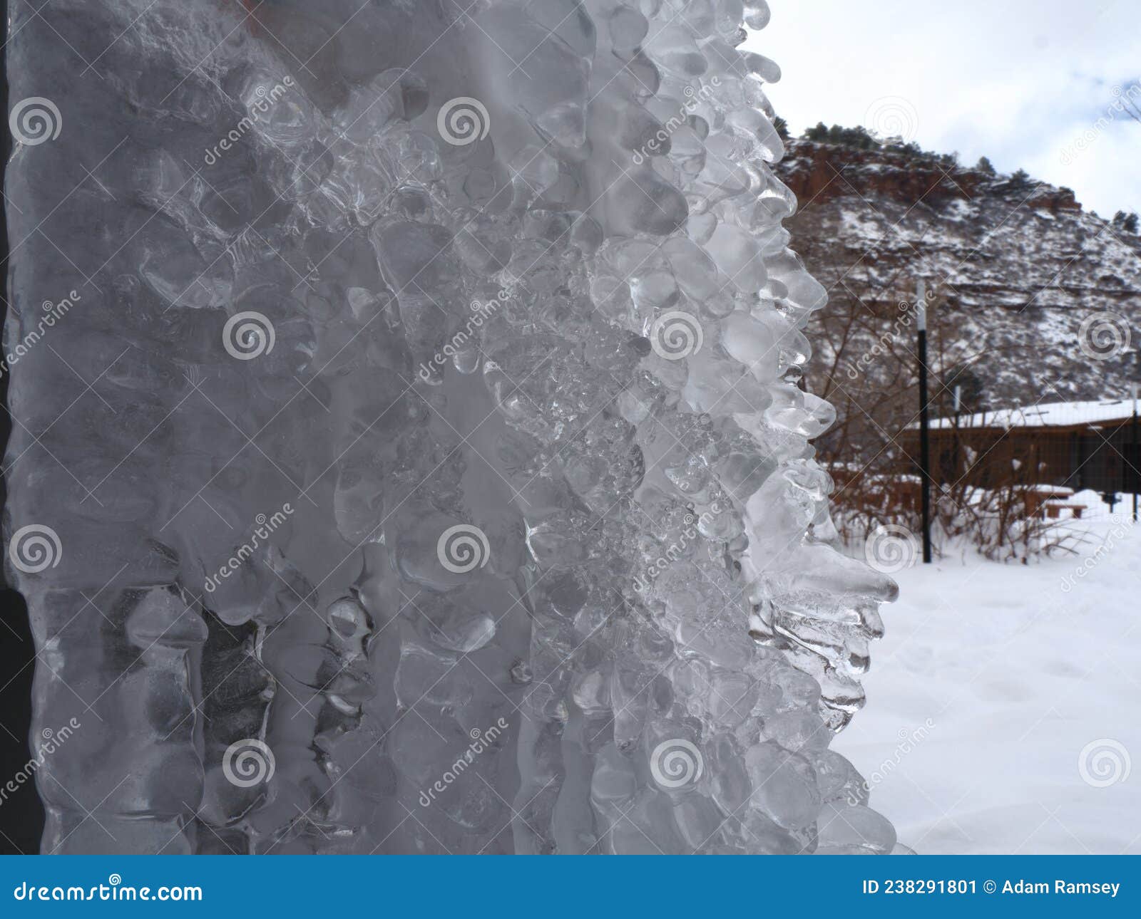 Upclose Shot of a Nubby Icey Wall with a Mountain in the Background ...