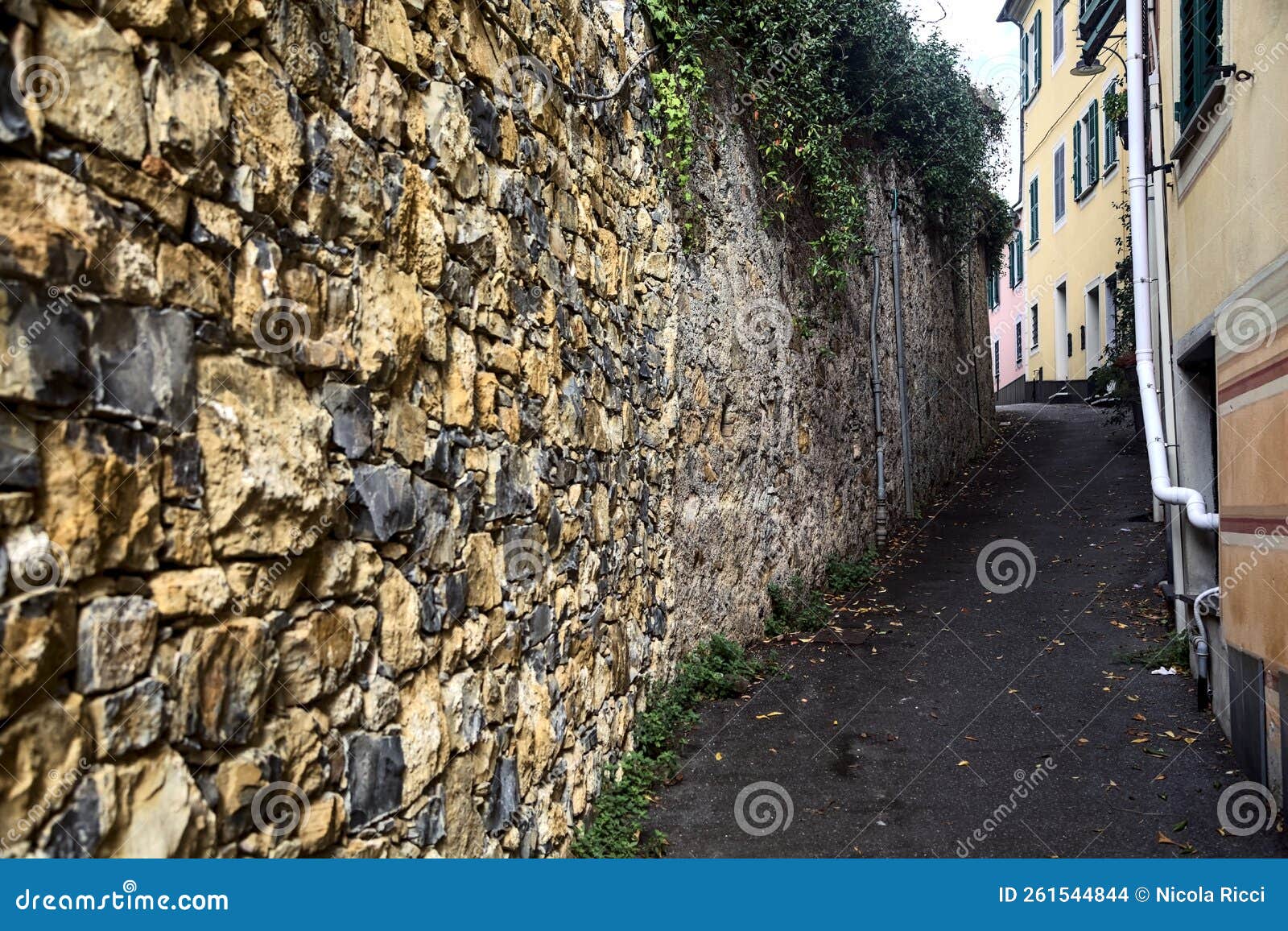 Uphill Alley between a Stone Wall and a Building Stock Photo - Image of ...