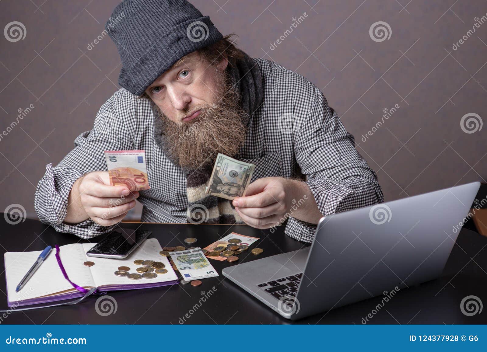 Upset Bearded Man in Knitted Hat Counting Money, Sitting beside Stock ... Upset Bearded Man in Knitted Hat Counting Money, Sitting beside Stock ...