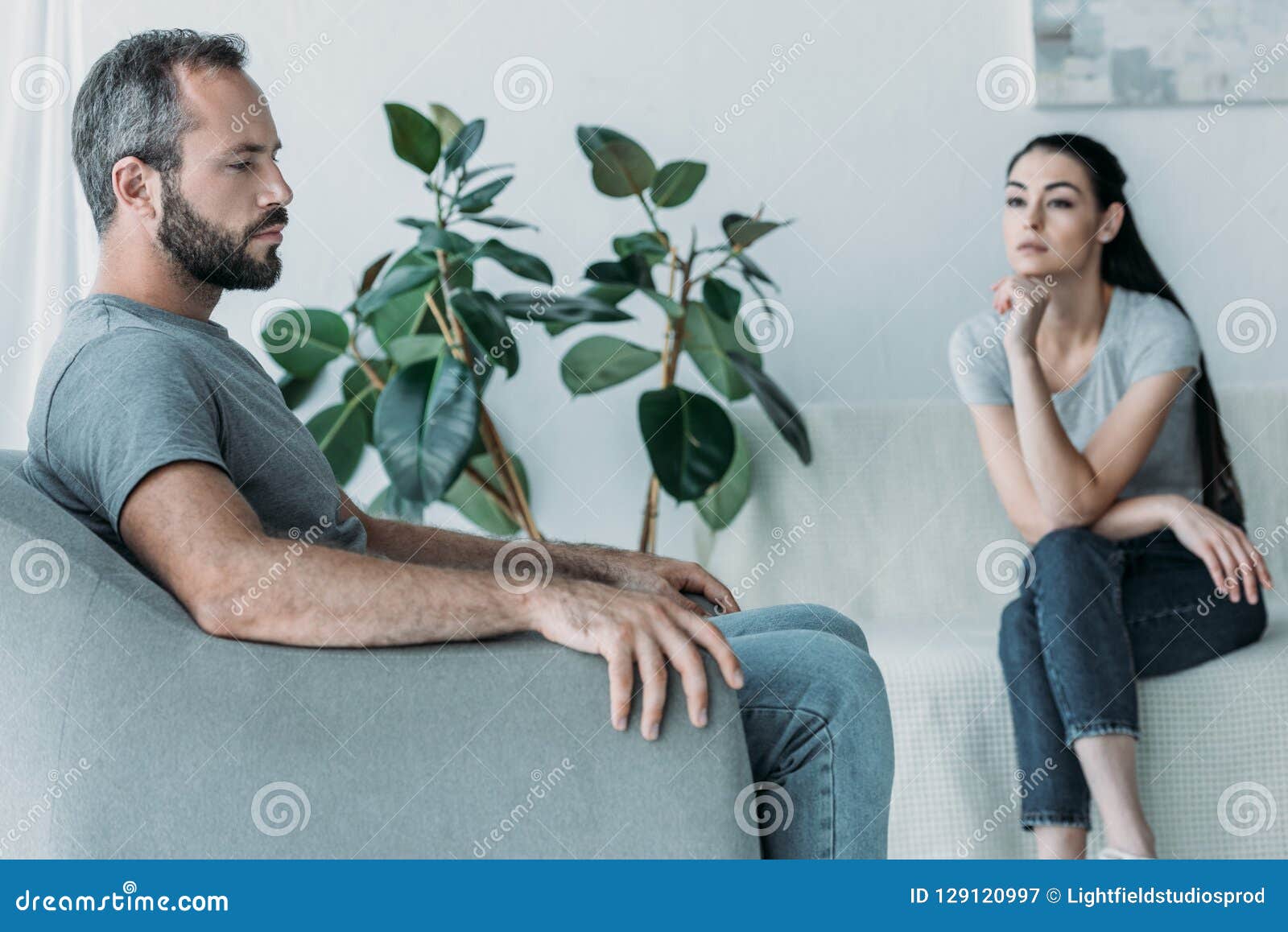Upset Bearded Man Sitting on Armchair and Frustrated Woman Sitting on ... Upset Bearded Man Sitting on Armchair and Frustrated Woman Sitting on ...