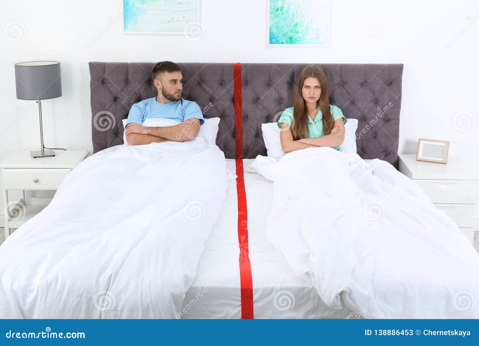 Upset Couple With Relationship Problems Lying Separately Stock Image