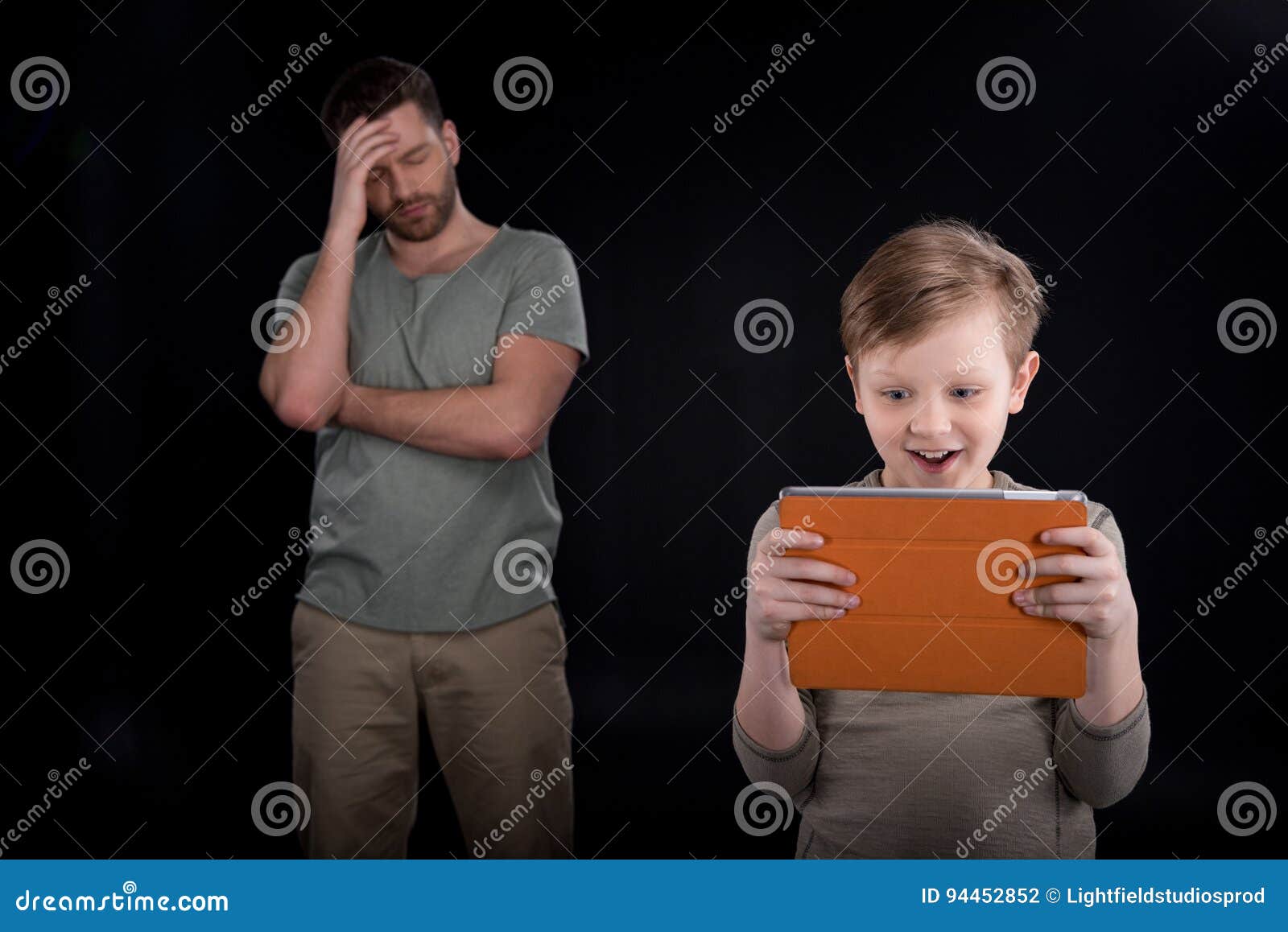 Upset Father Standing Behind Excited Son Using Digital Tablet Stock ...