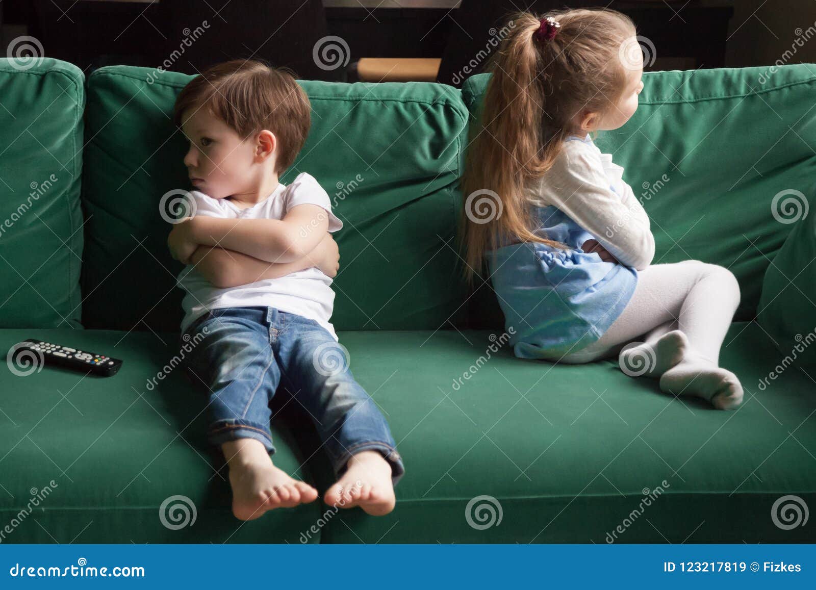 Upset Siblings Sitting On Sofa Ignoring Each Other After Fight Stock