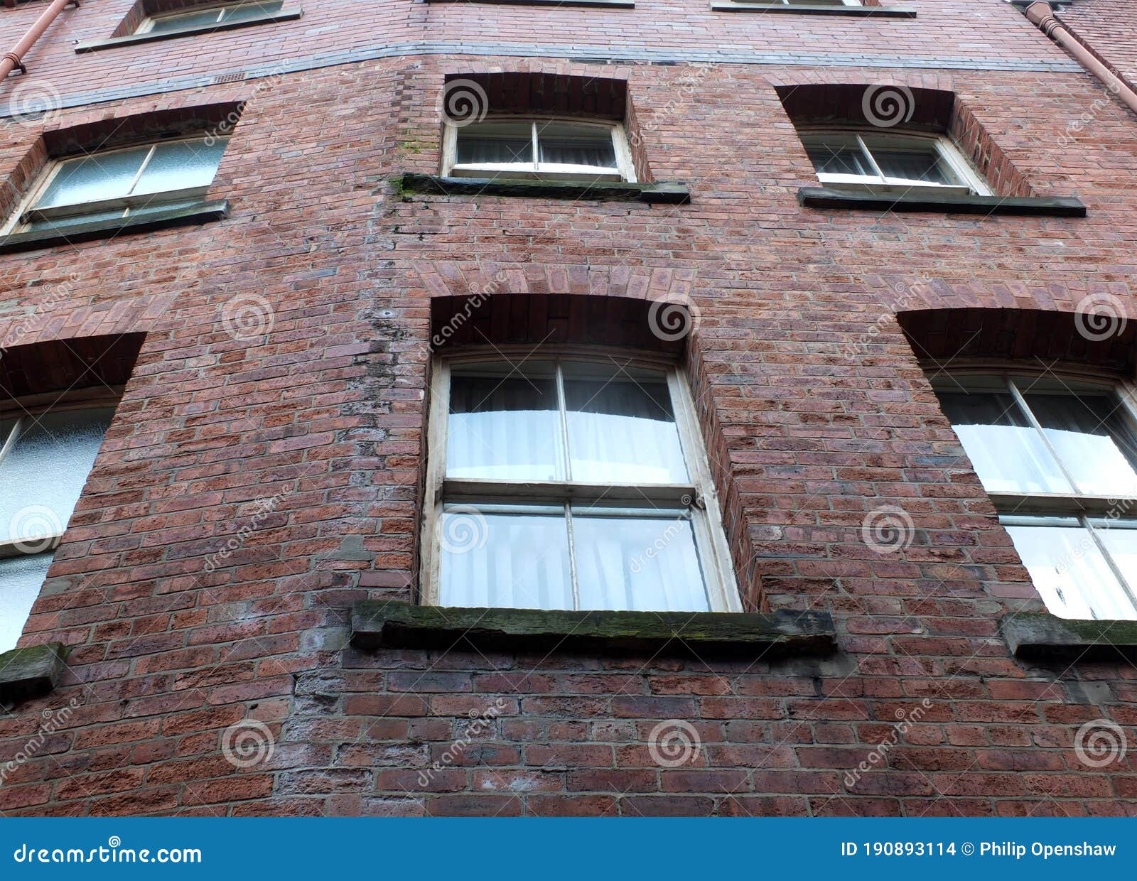 Upwards View of a Large Old Red Brick Building with Rows of Narrow ...