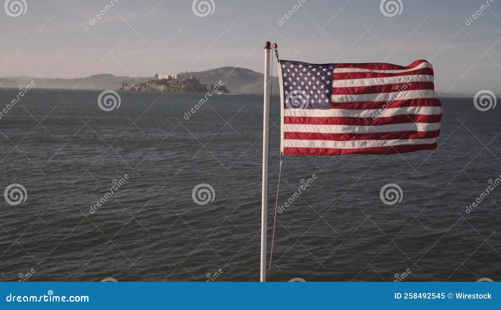 US Flag Waving in the Wind with Alcatraz Island in the Background Stock ...