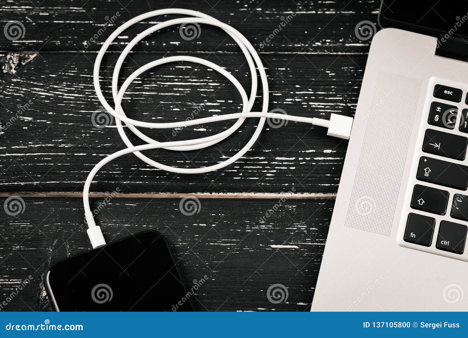 A USB Cable Connects Your Phone and Laptop. on the Black Table Stock ...