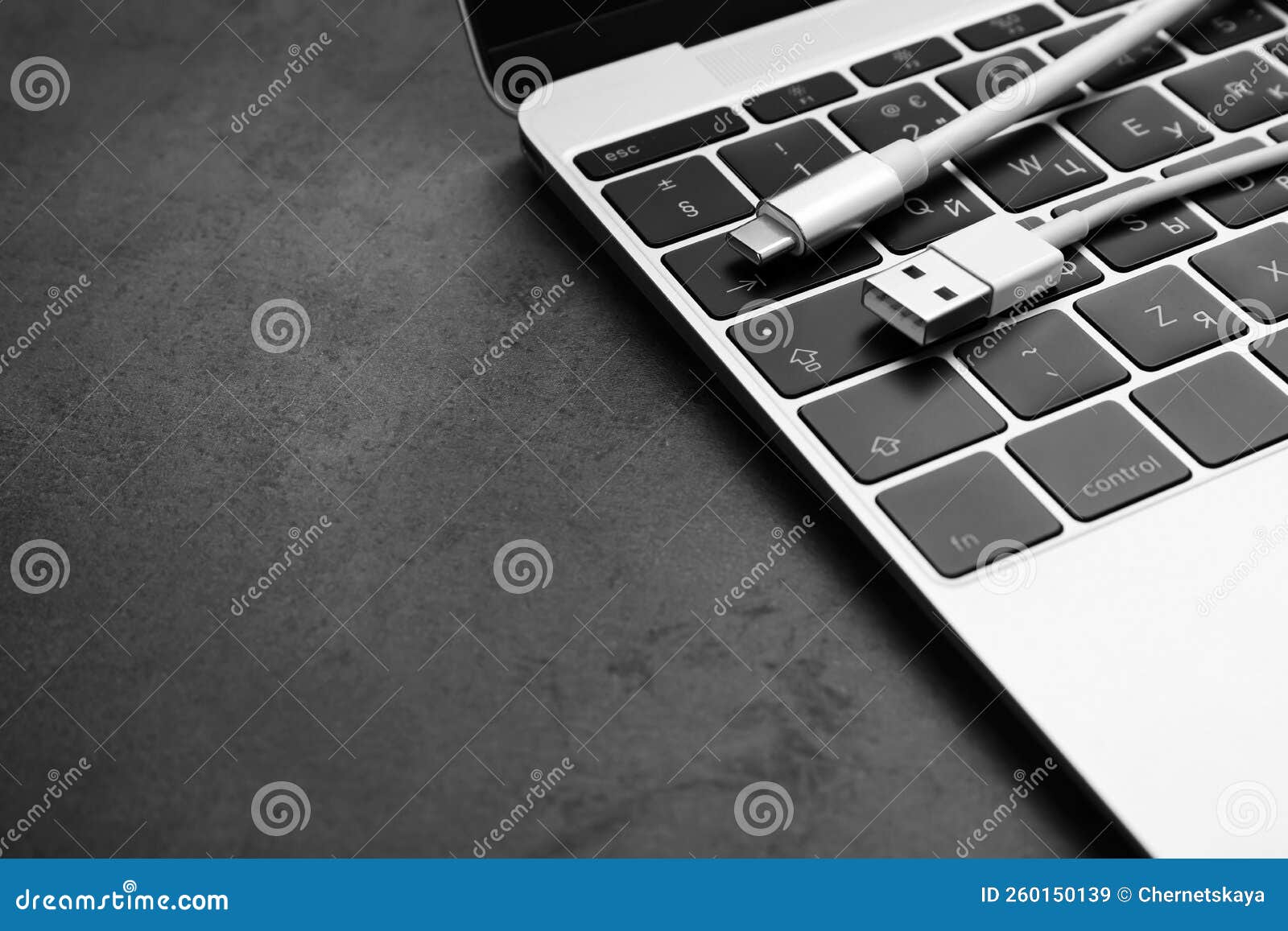 USB Cable with Type C Connector and Laptop on Dark Table, Closeup ...