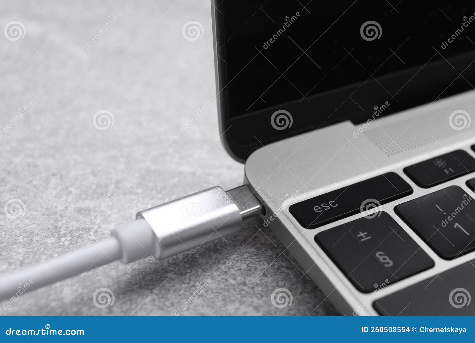 USB Cable with Type C Connector Plugged into Laptop Port on Grey Table ...
