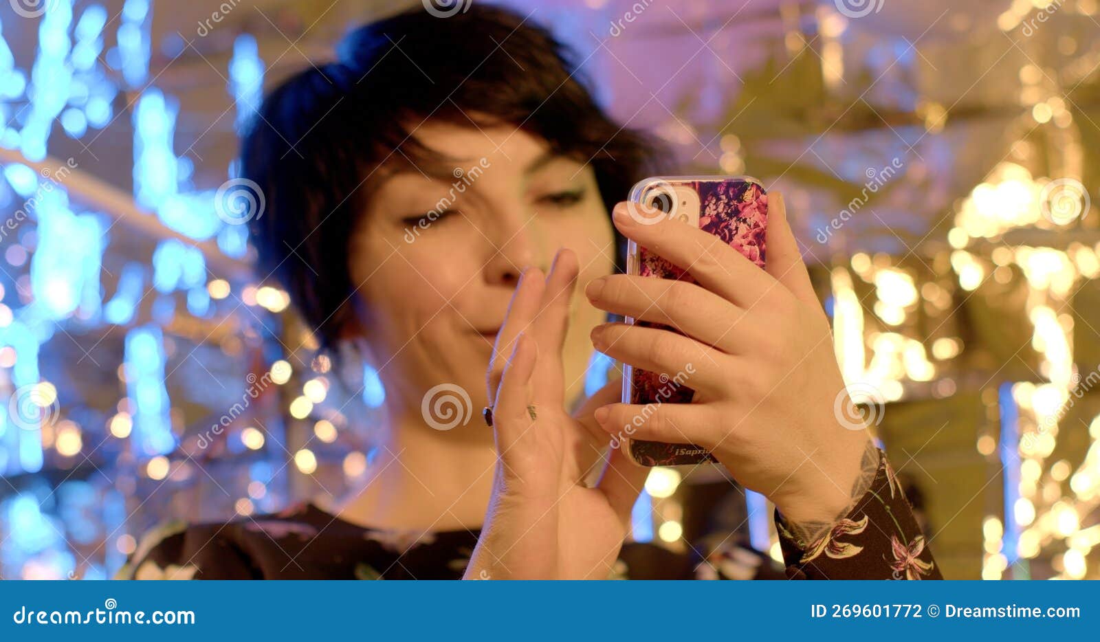 She Uses the Phone in Her Hands Against the Backdrop of Light ...