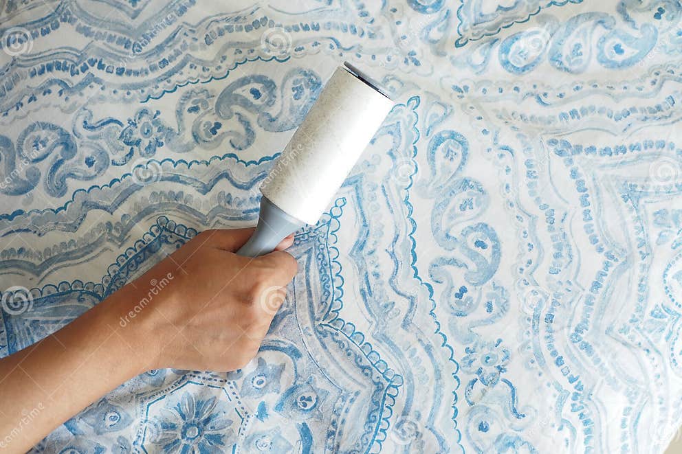 Using an Adhesive Roller To Remove Lint and Fluff from a Bed . Stock ...