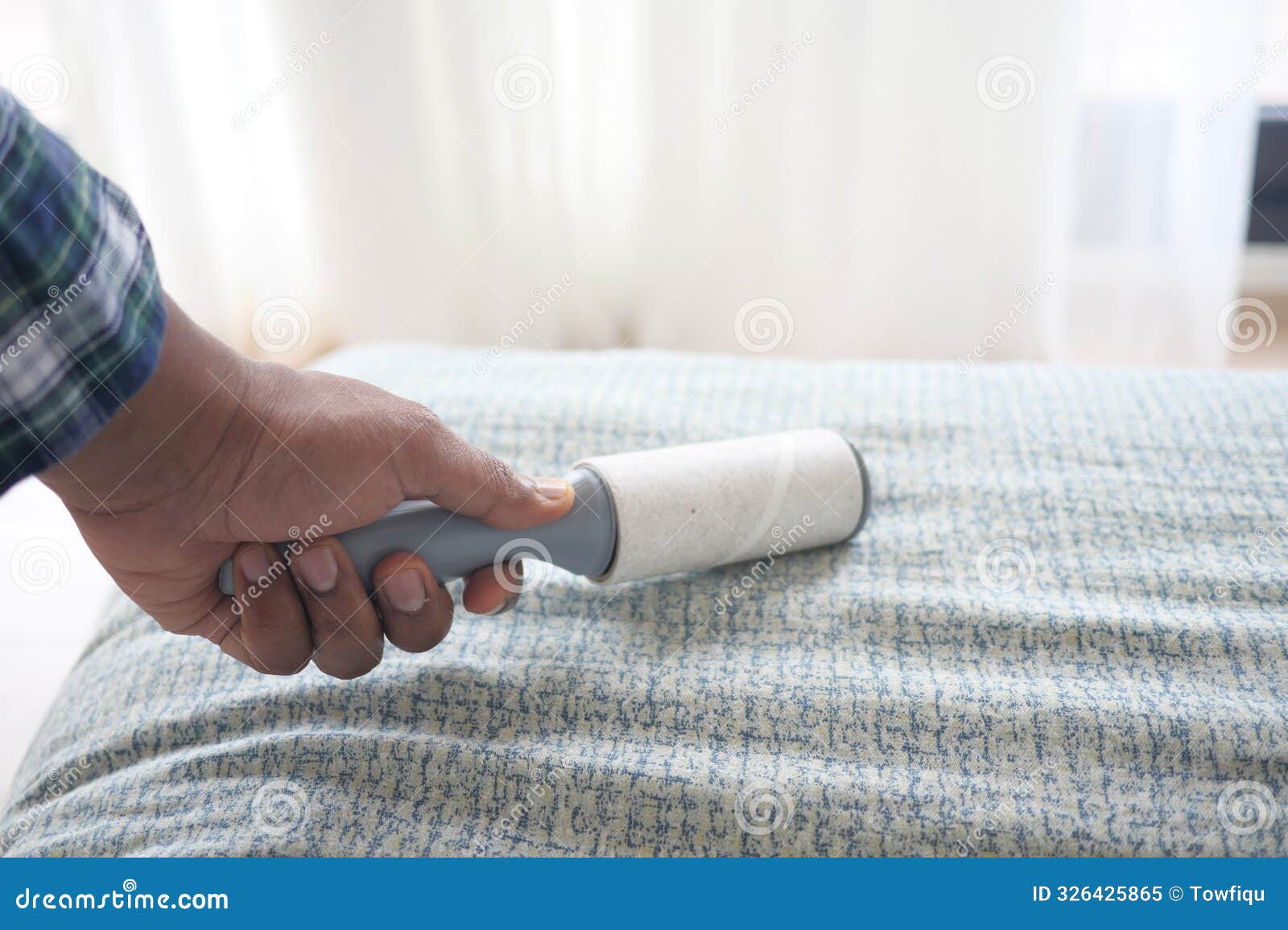 Using an Adhesive Roller To Remove Lint and Fluff from a Bed . Stock ...