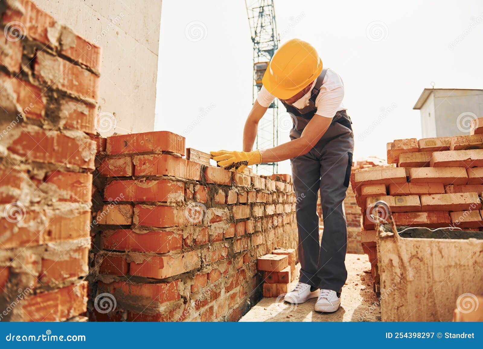 Using Bricks. Young Construction Worker in Uniform is Busy at the ...