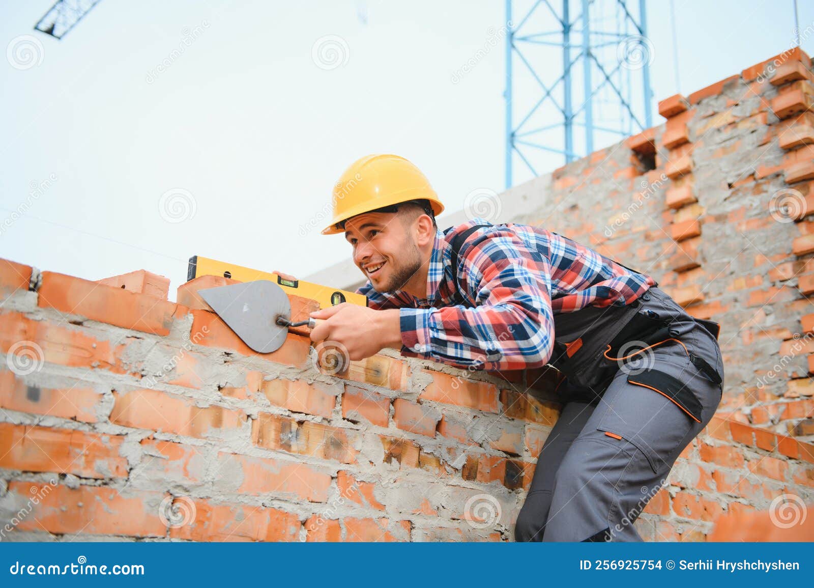 Using Bricks. Young Construction Worker in Uniform is Busy at the ...