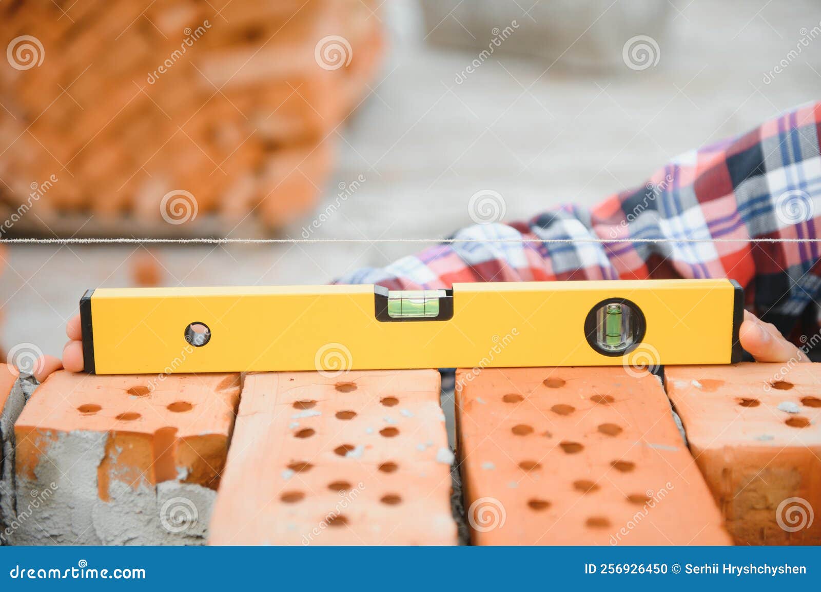 Using Bricks. Young Construction Worker in Uniform is Busy at the ...