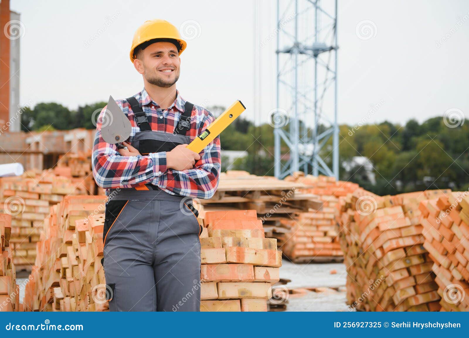 Using Bricks. Young Construction Worker in Uniform is Busy at the ...