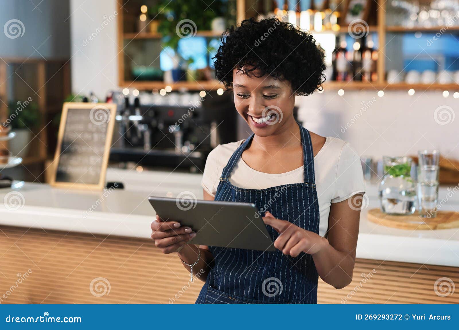 Using Digital Solutions To Best Manage Her Cafe. a Young Woman Using a ...