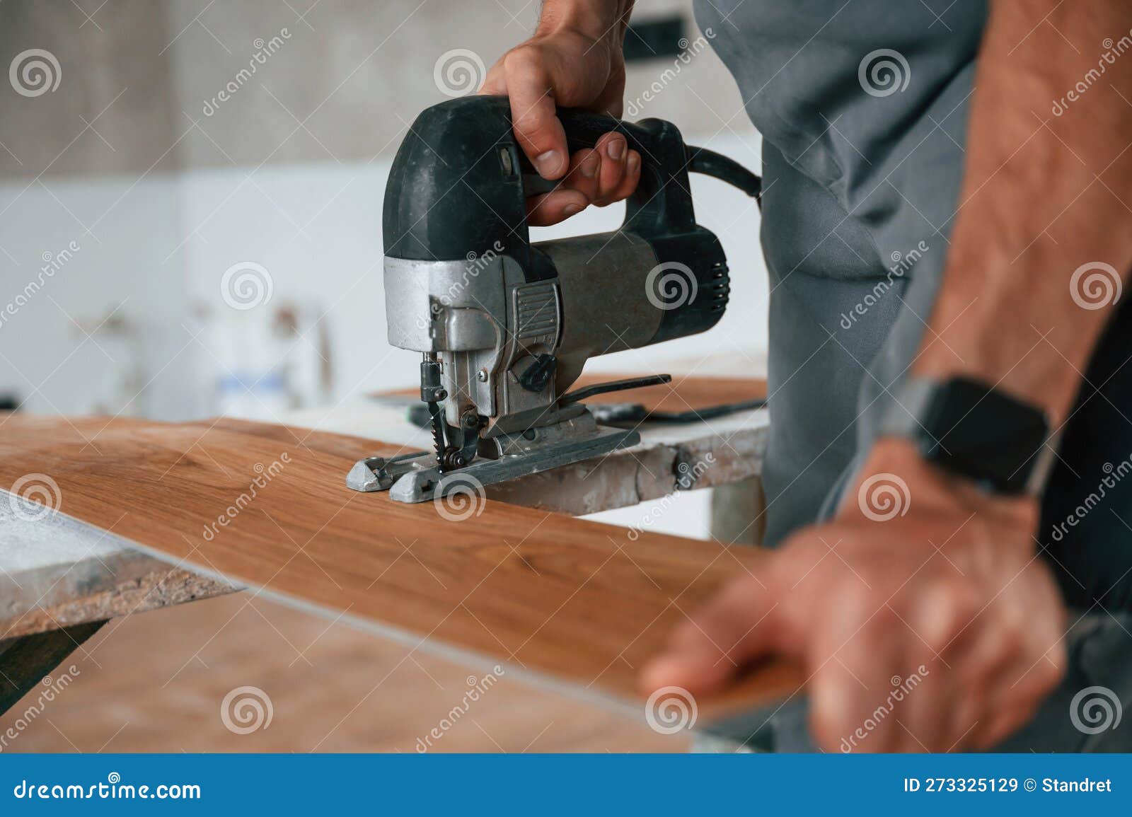Using the Electric Machine Tool To Cut the Plank. Man is Installing New ...