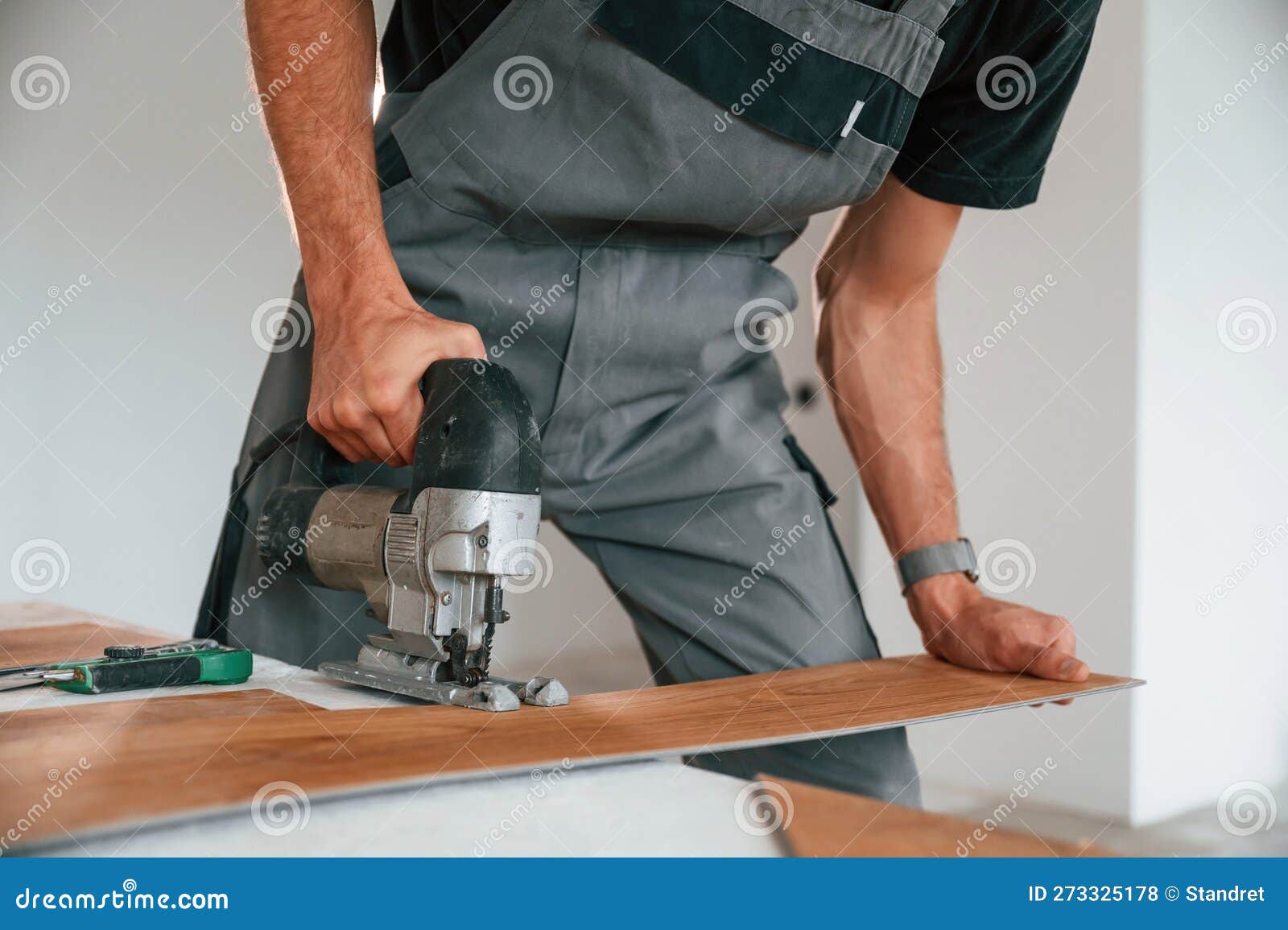 Using the Electric Machine Tool To Cut the Plank. Man is Installing New ...