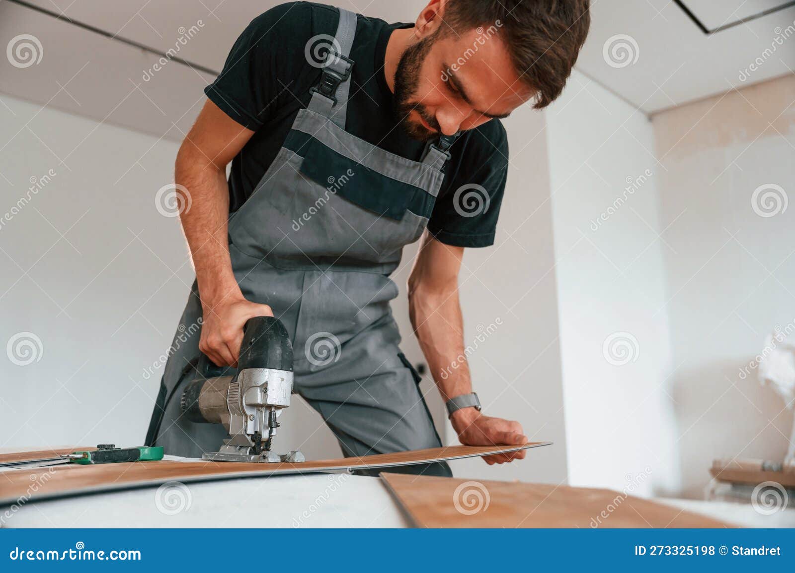 Using the Electric Machine Tool To Cut the Plank. Man is Installing New ...