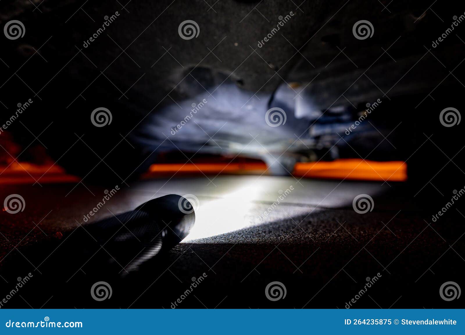 Looking Under a SUV at Night with a Flashlight To Inspect Problems ...