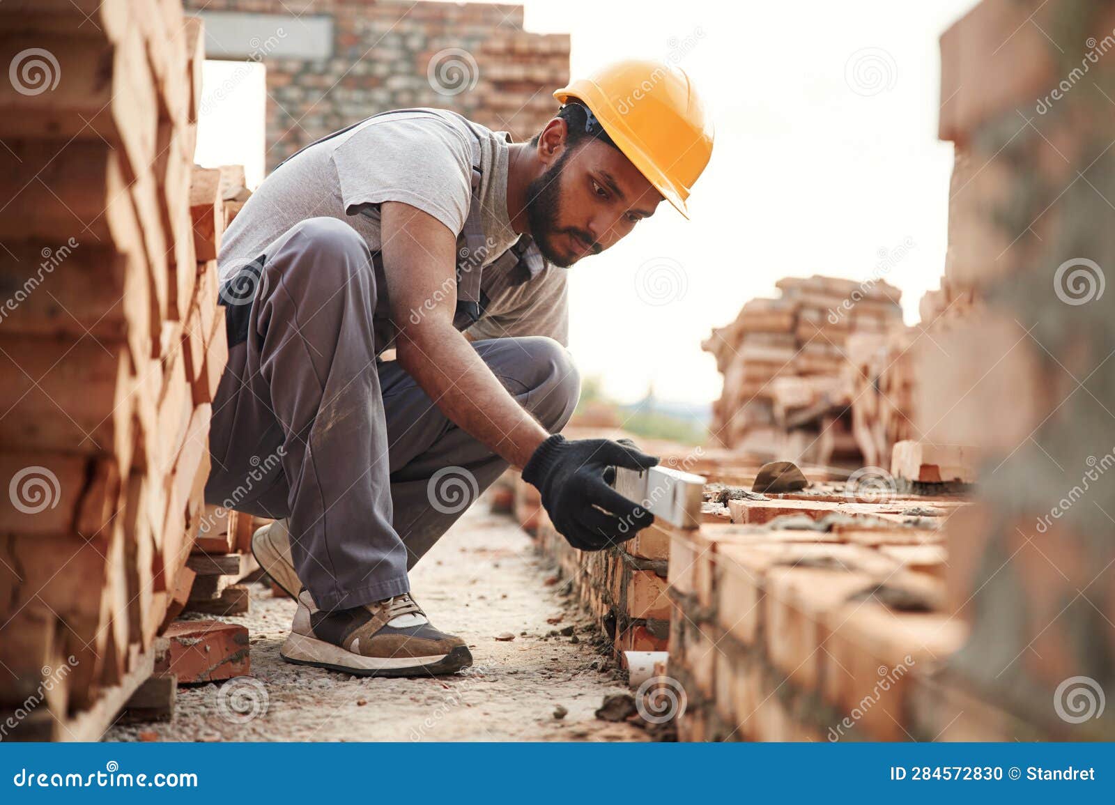Showing and Holding Little Shovel and Brick. Handsome Indian Man is on ...