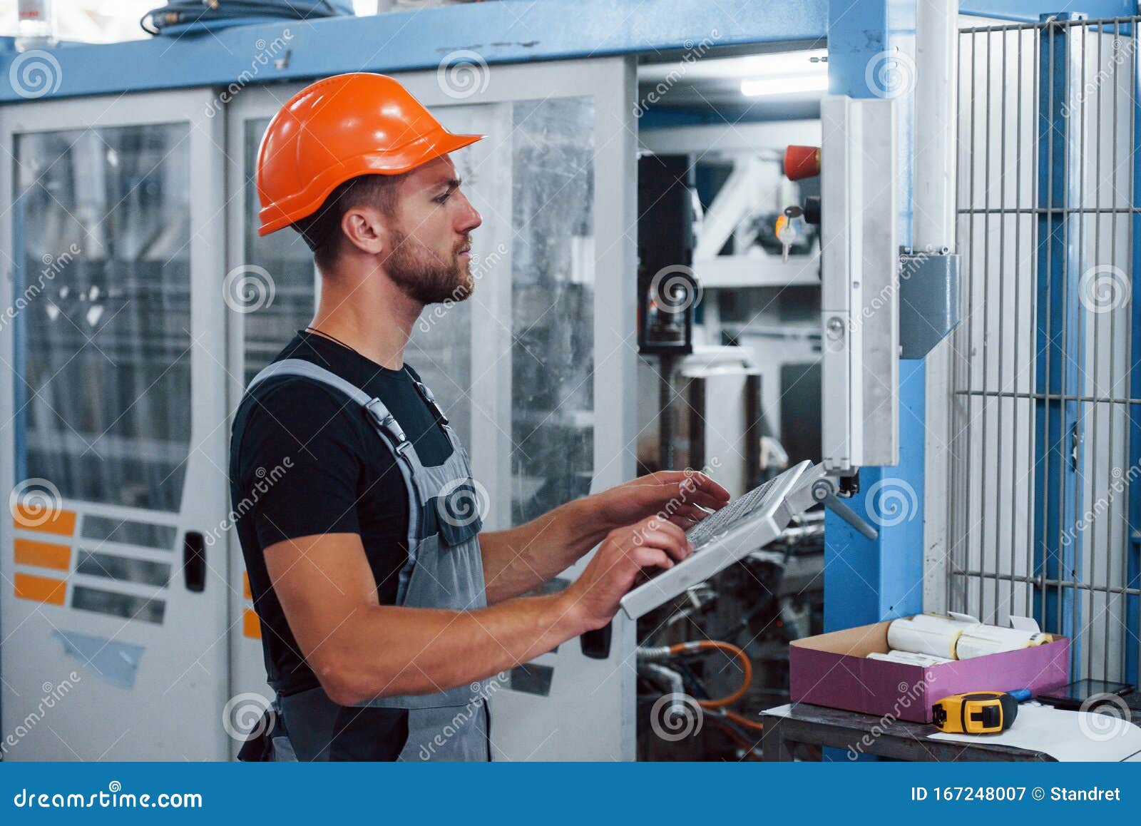 Using Machine To Program Operations. Industrial Worker Indoors in ...
