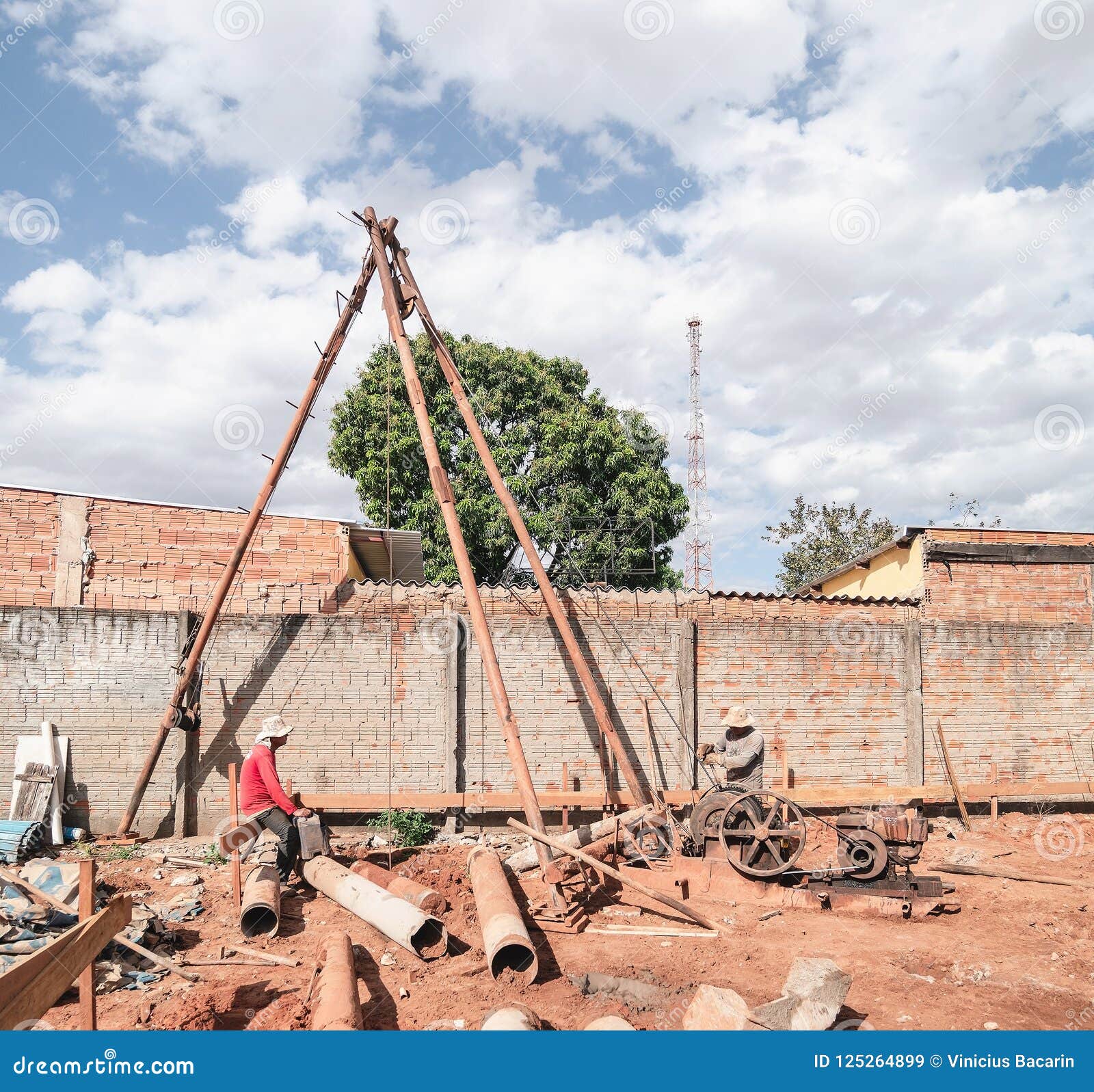 Using a Pile Driver on a Tripod To Dig the Soil and Make the Foundation ...
