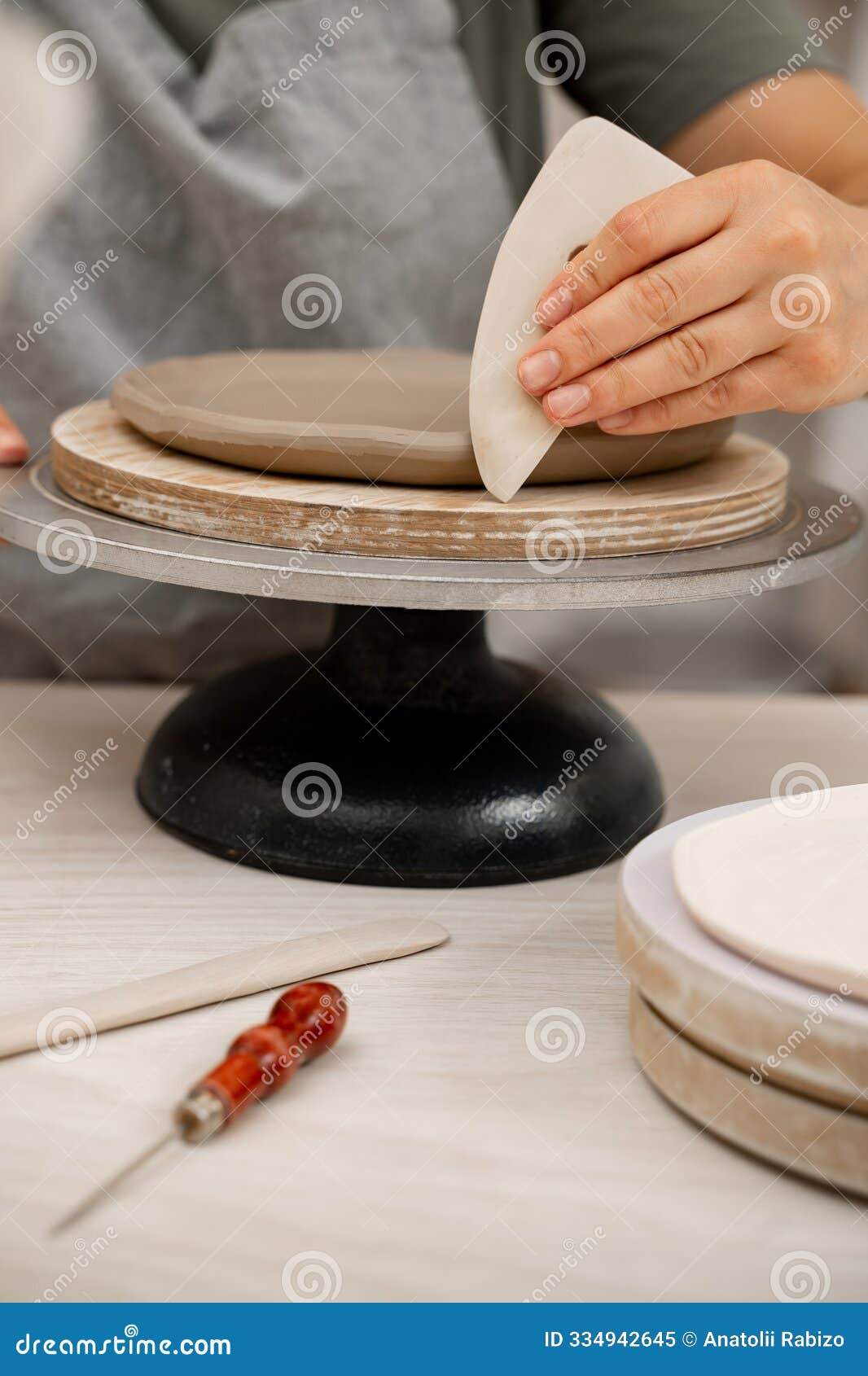 Using a Pottery Scrapper To Smooth the Edges of a Clay Product ...