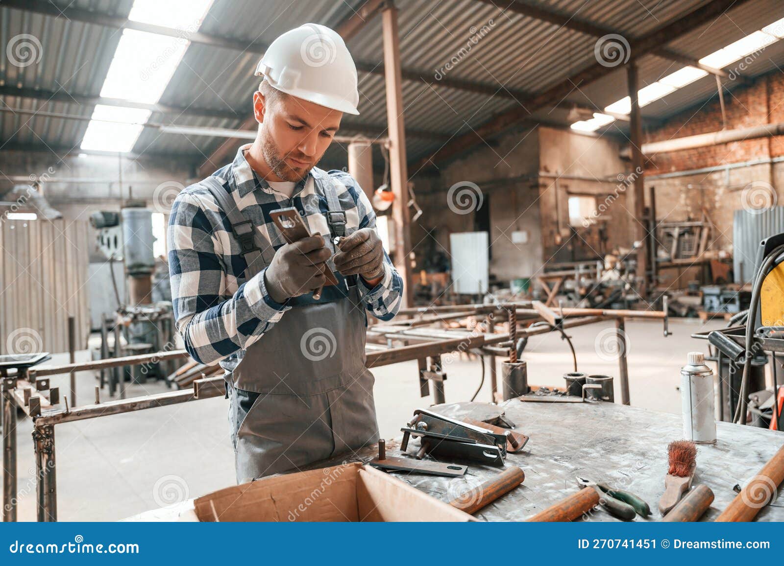 Using Professional Tools. Factory Male Worker in Uniform is Indoors ...