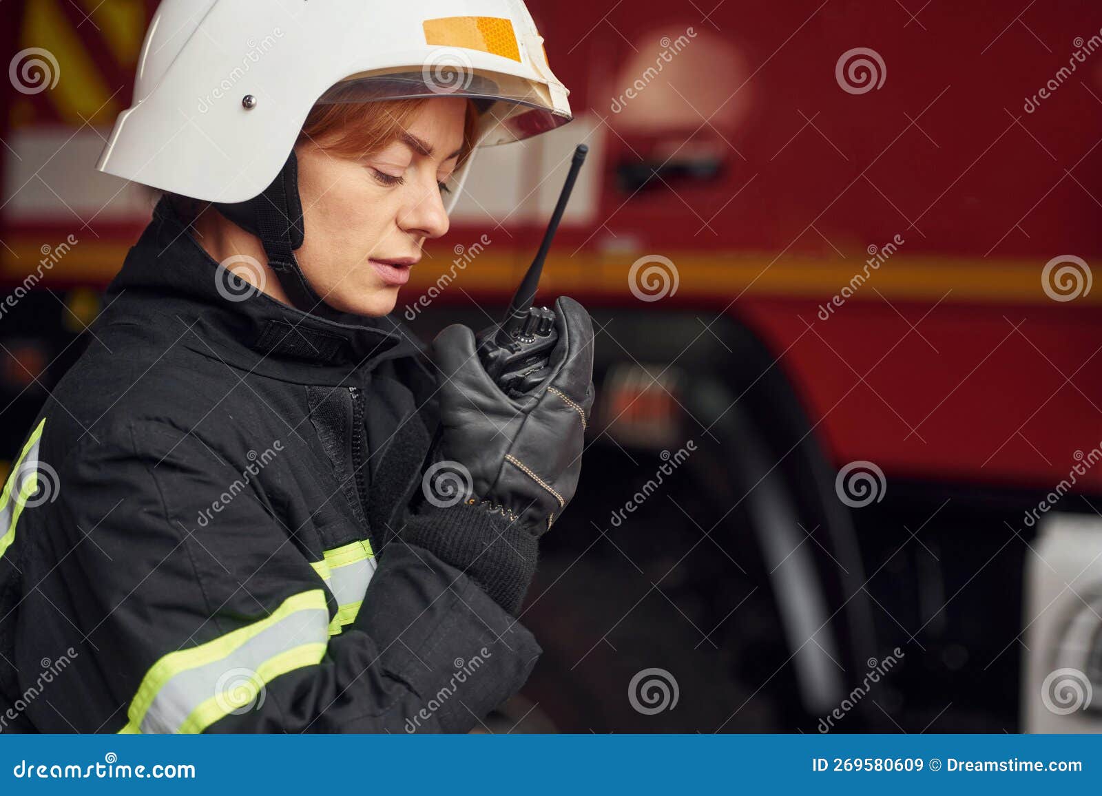 Using Radio Transmitter. Woman Firefighter in Uniform is at Work in ...
