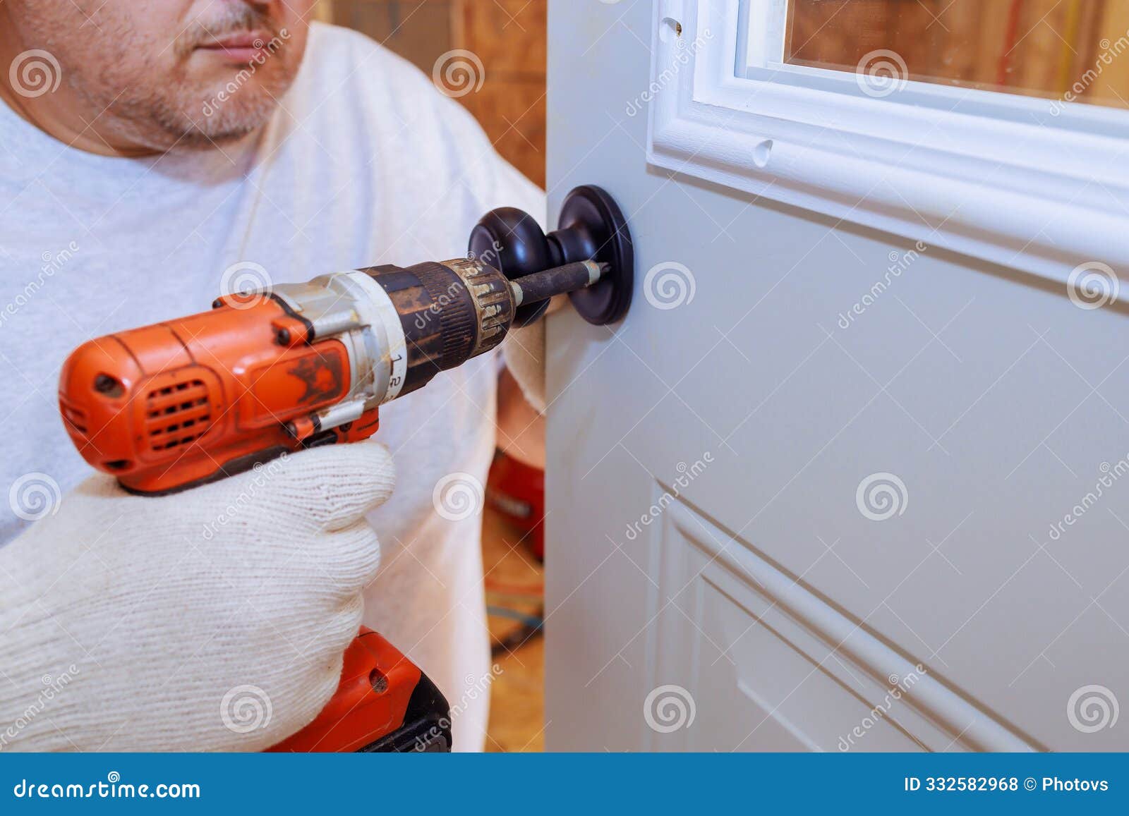 Using Screwdriver, Locksmith Installs Lock on Entrance Door of a House ...