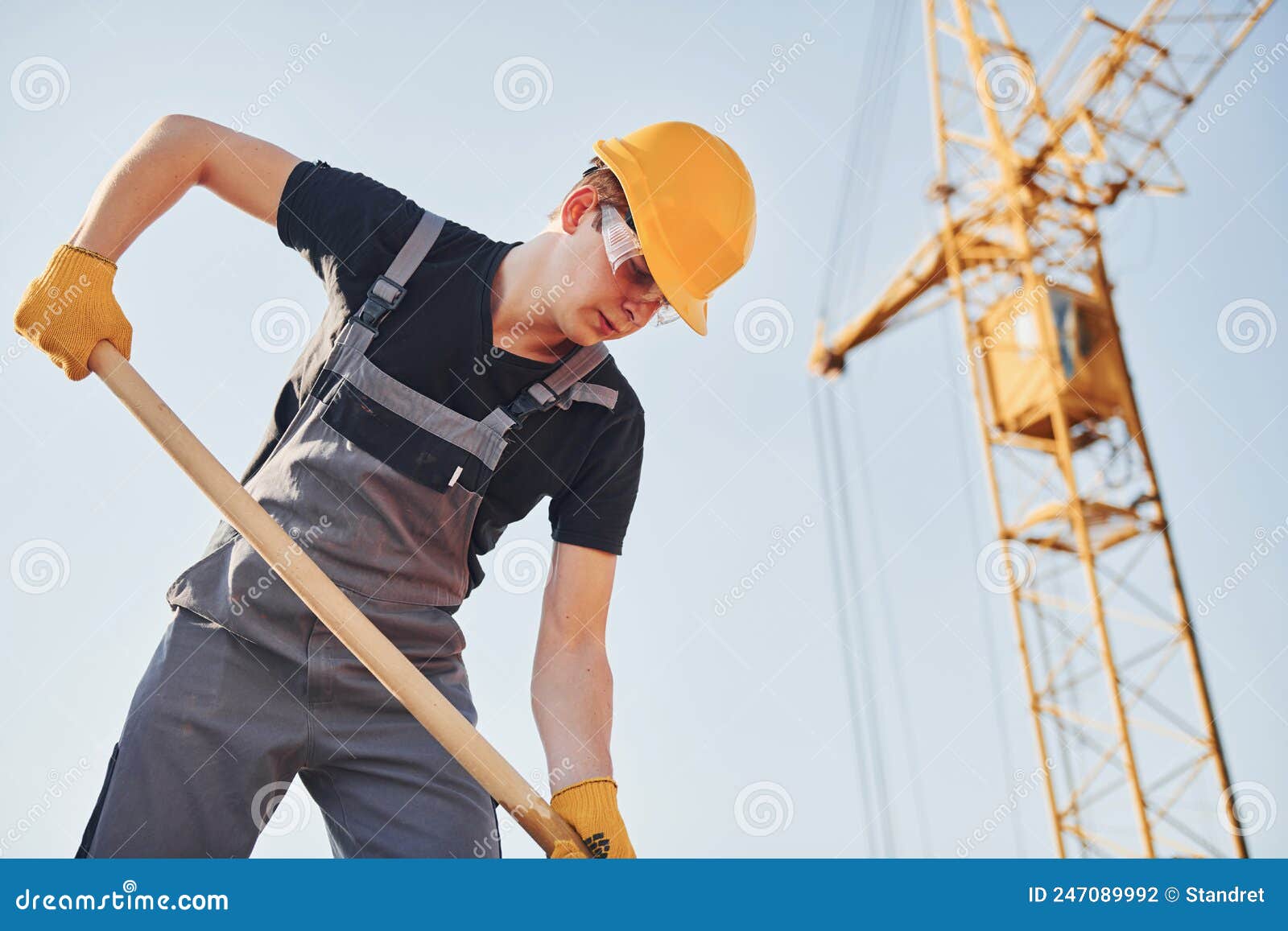 Using Showel. Construction Worker in Uniform and Safety Equipment Have ...